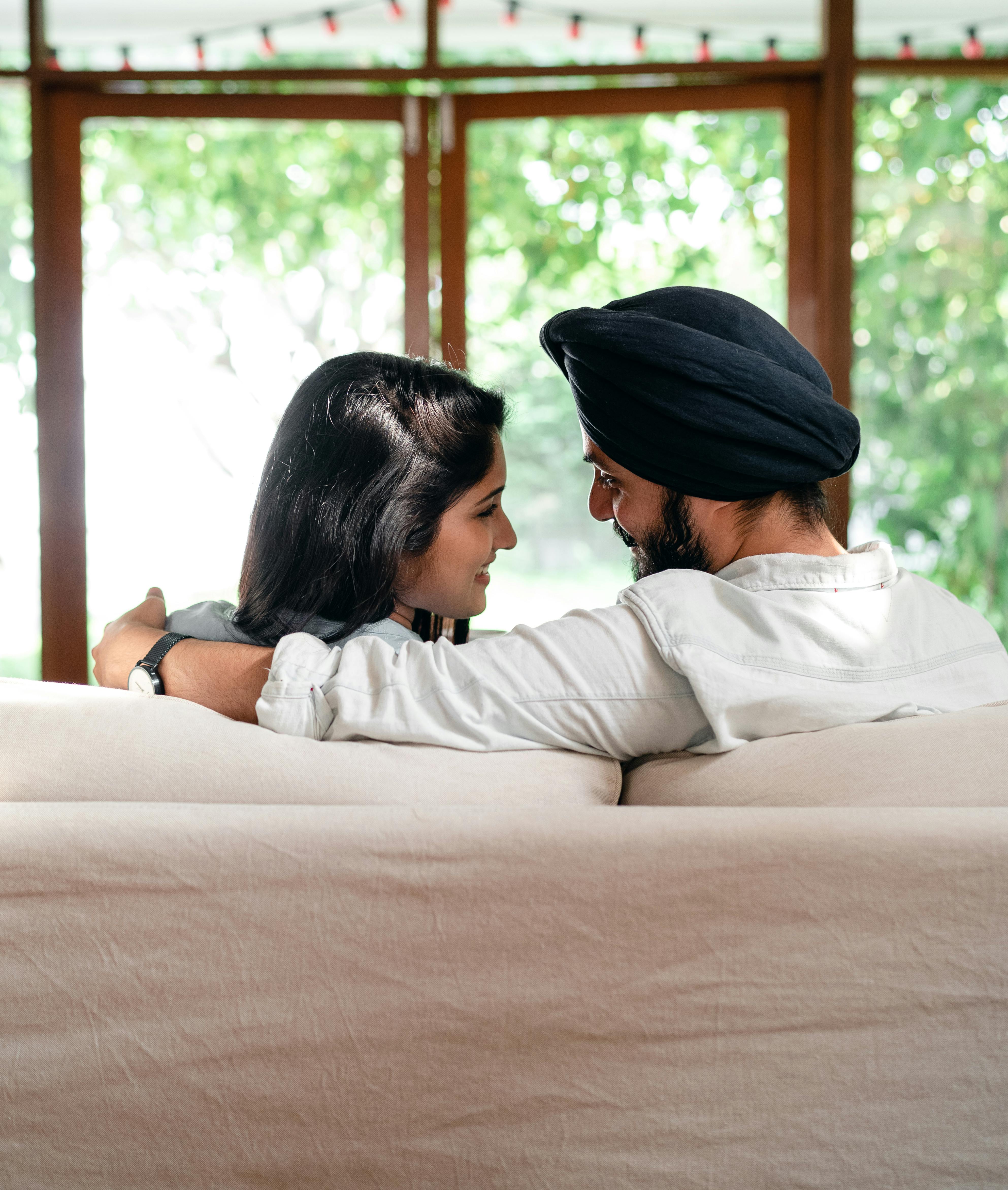 Tender young Indian couple hugging while sitting on couch · Free Stock ...