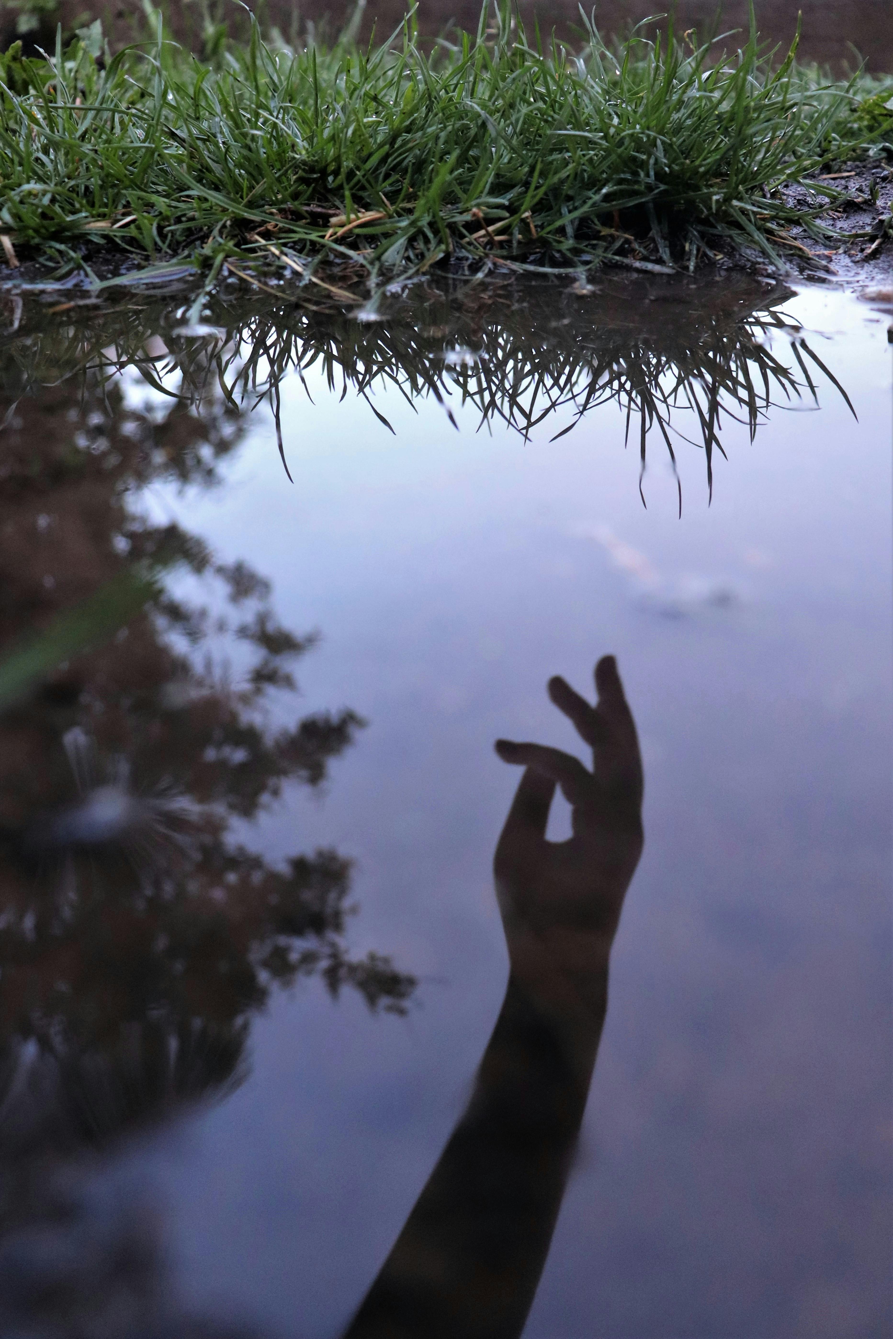 A Reflection of a Hand on a Water Surface · Free Stock Photo
