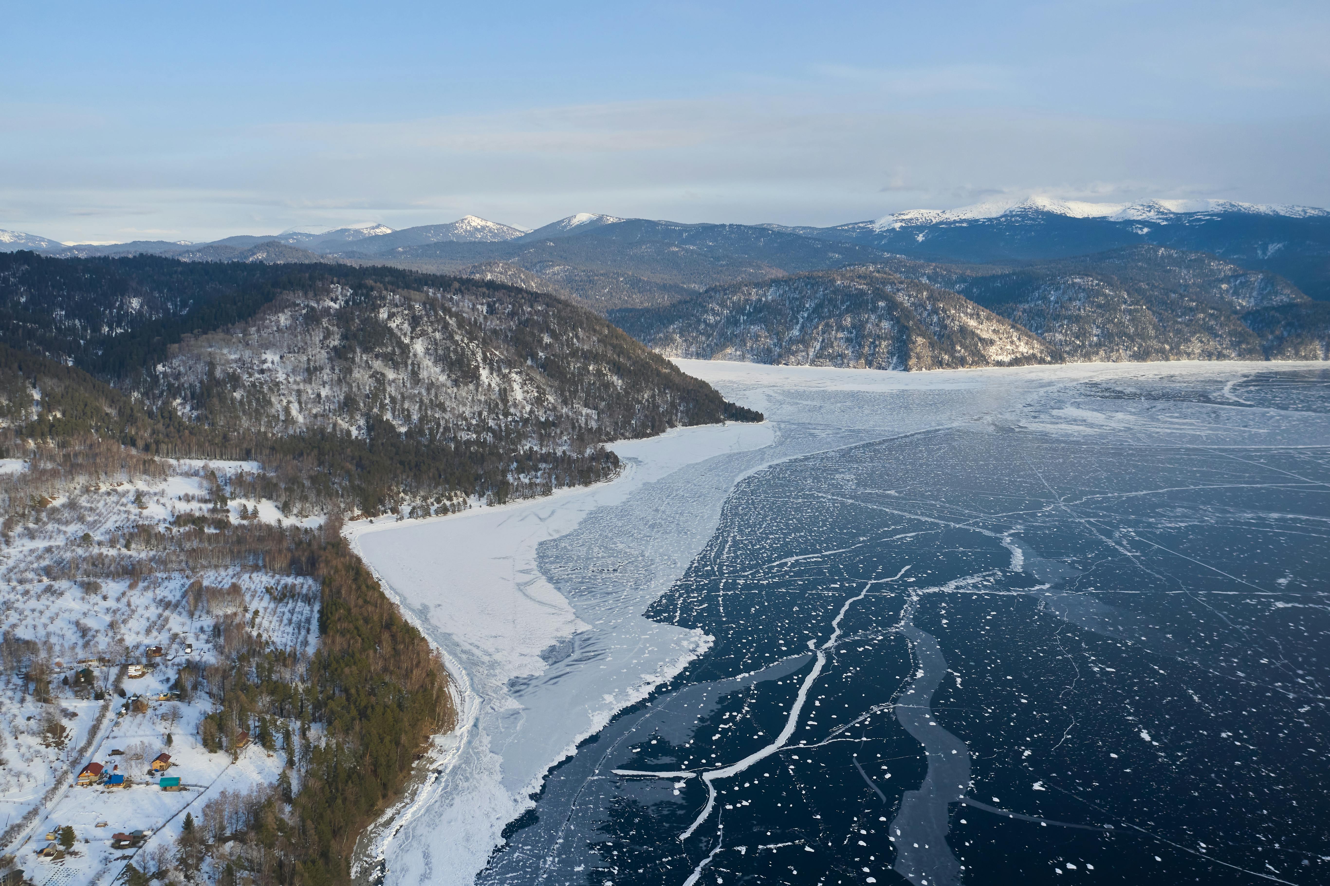 Snowy mountains near frozen lake in winter · Free Stock Photo