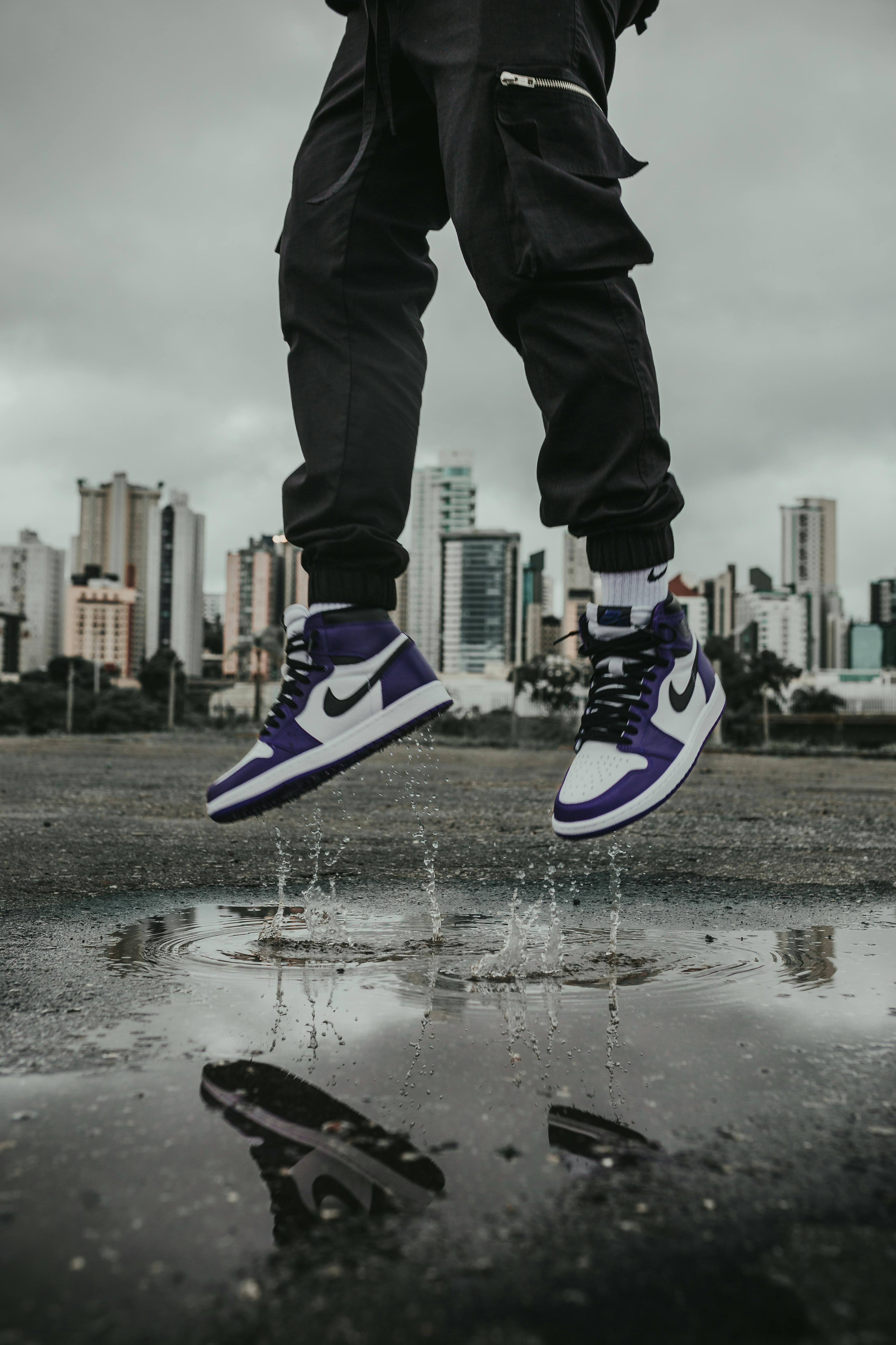 Young man on sidewalk jumping off railing on street · Free Stock Photo