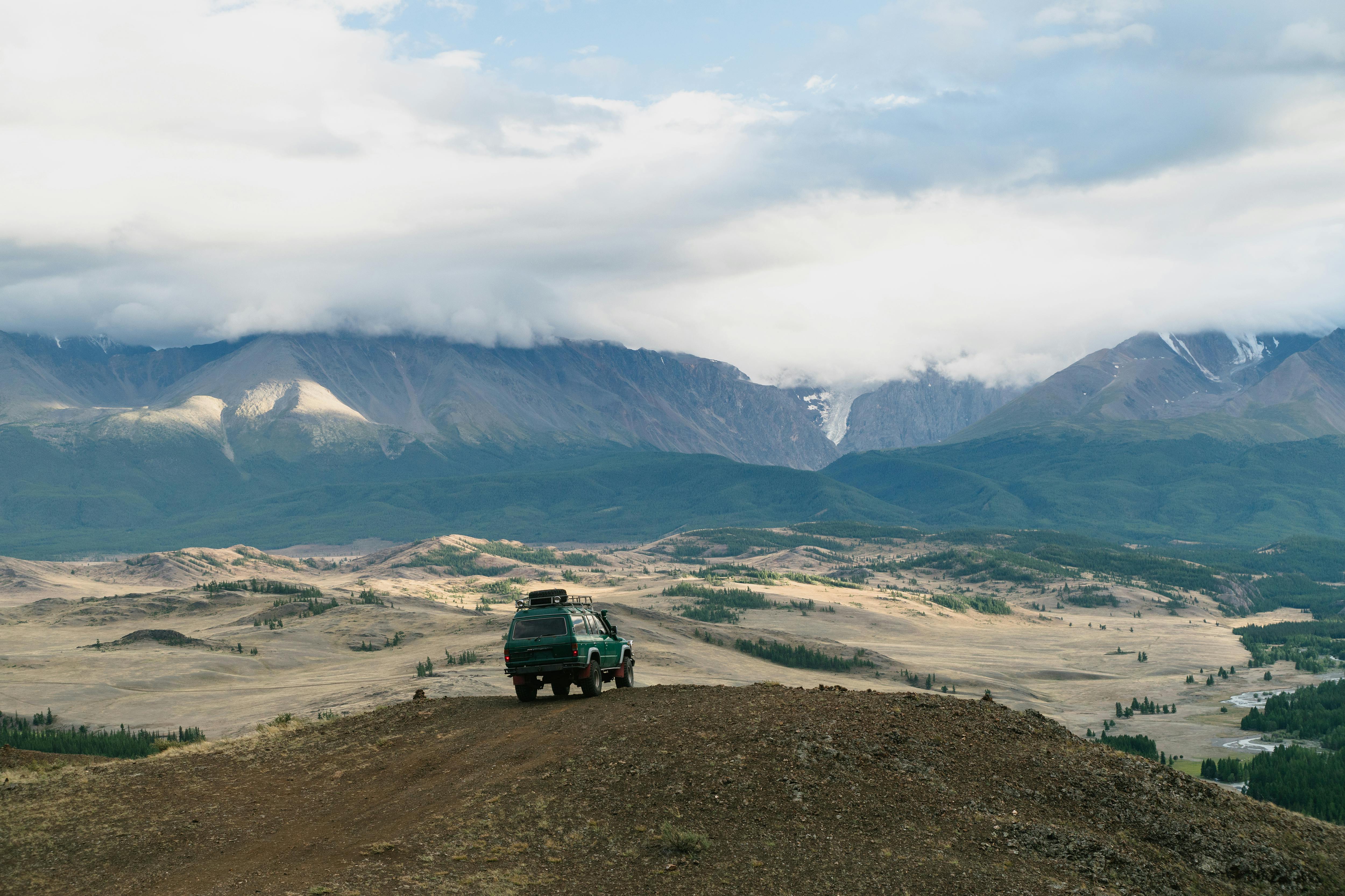 A Car Driving Through Hills and Mountains · Free Stock Photo