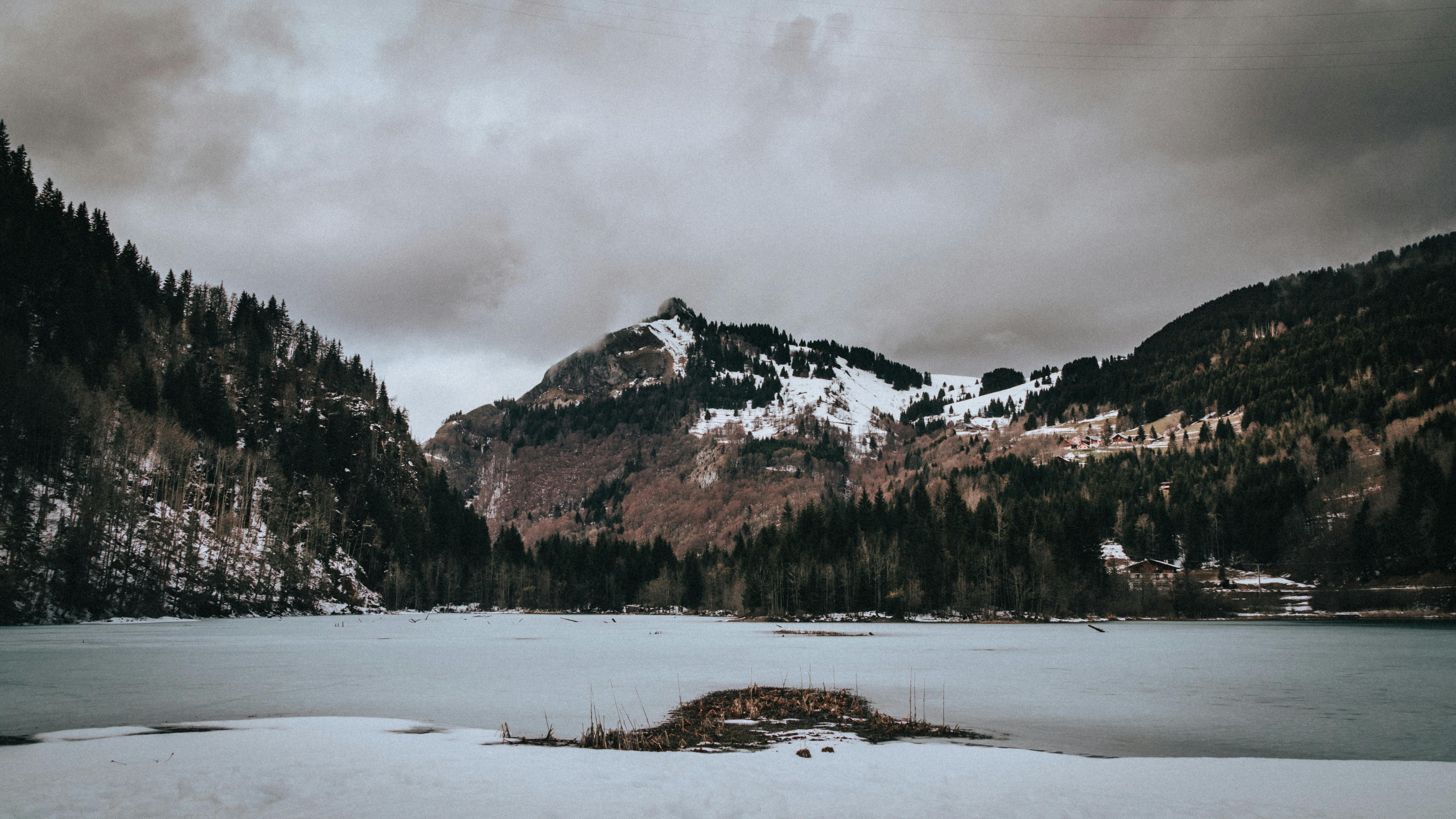 Snowy ridge under cloudy sky in wintertime · Free Stock Photo