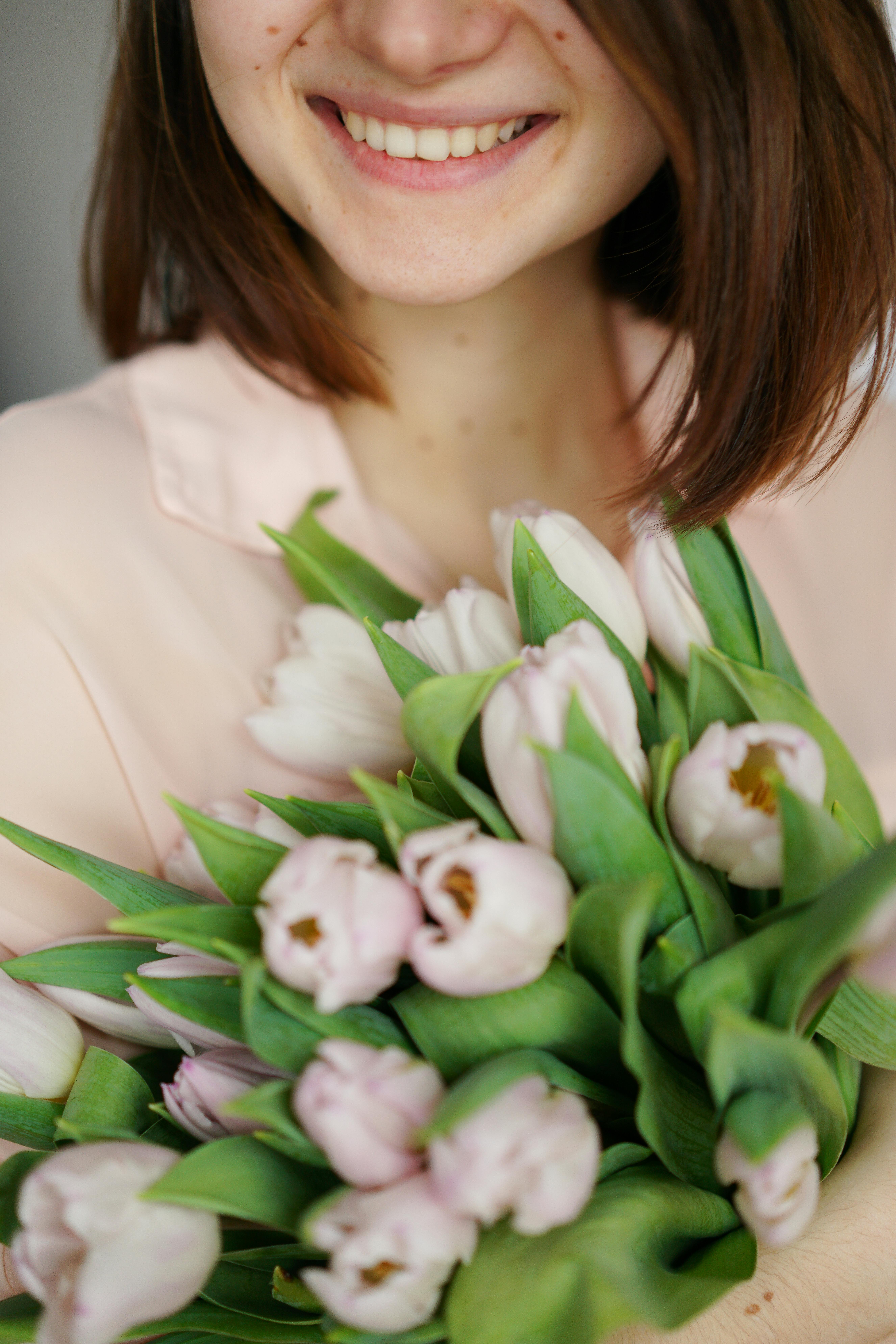 Crop smiling lady with tulip flowers · Free Stock Photo