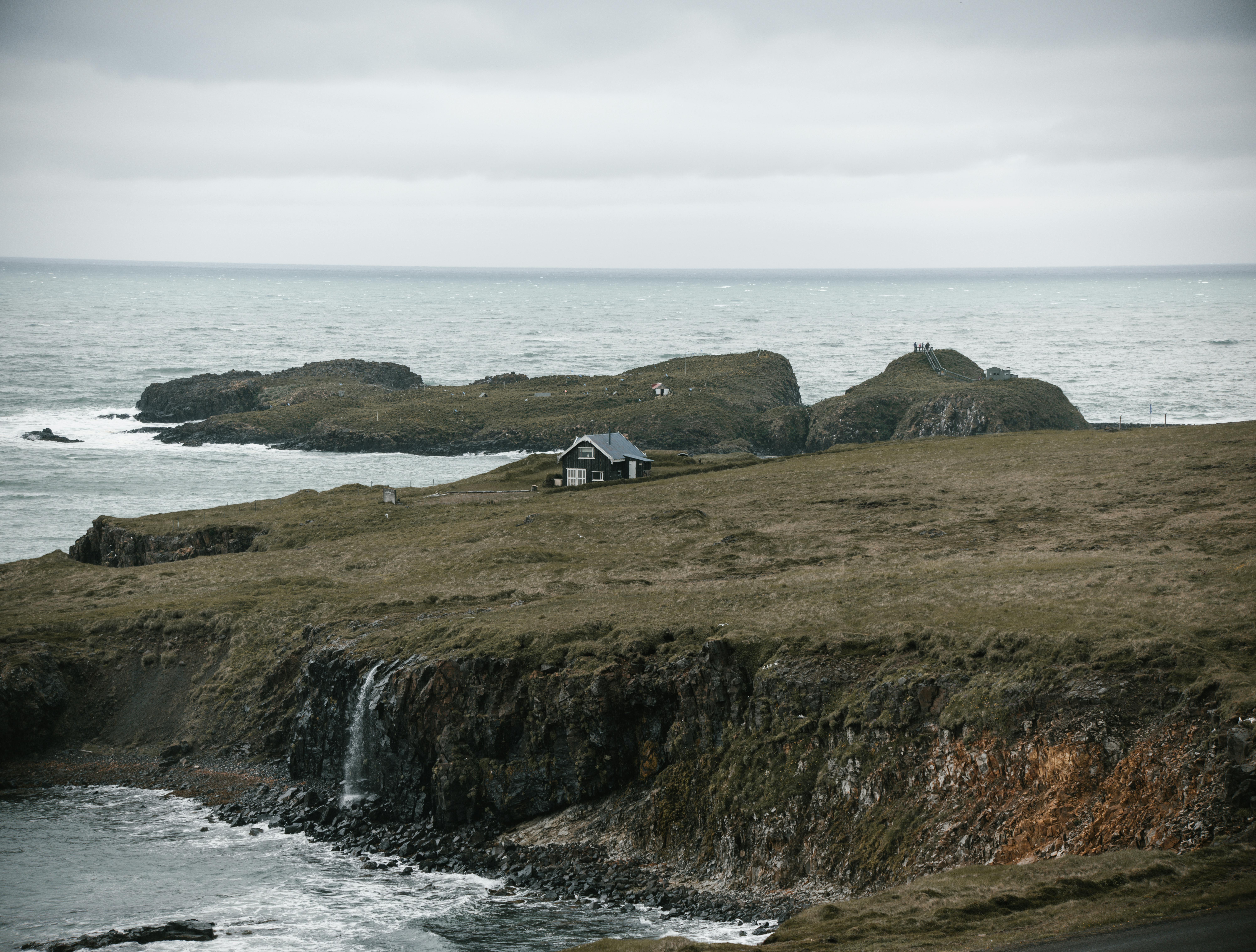 Rocky seashore with lonesome remote house · Free Stock Photo