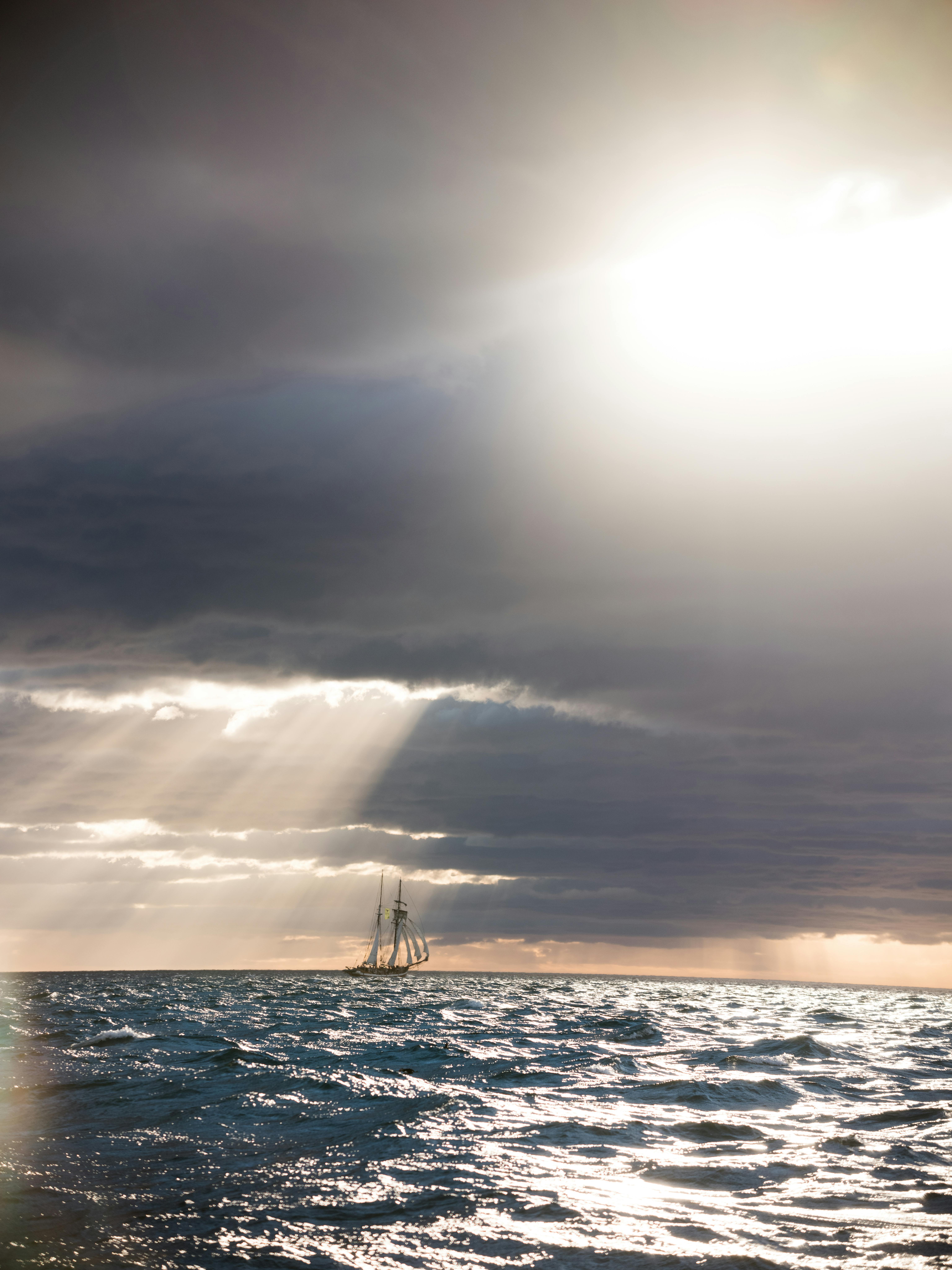Picturesque scenery of sunset over ocean and lonely floating ship ...