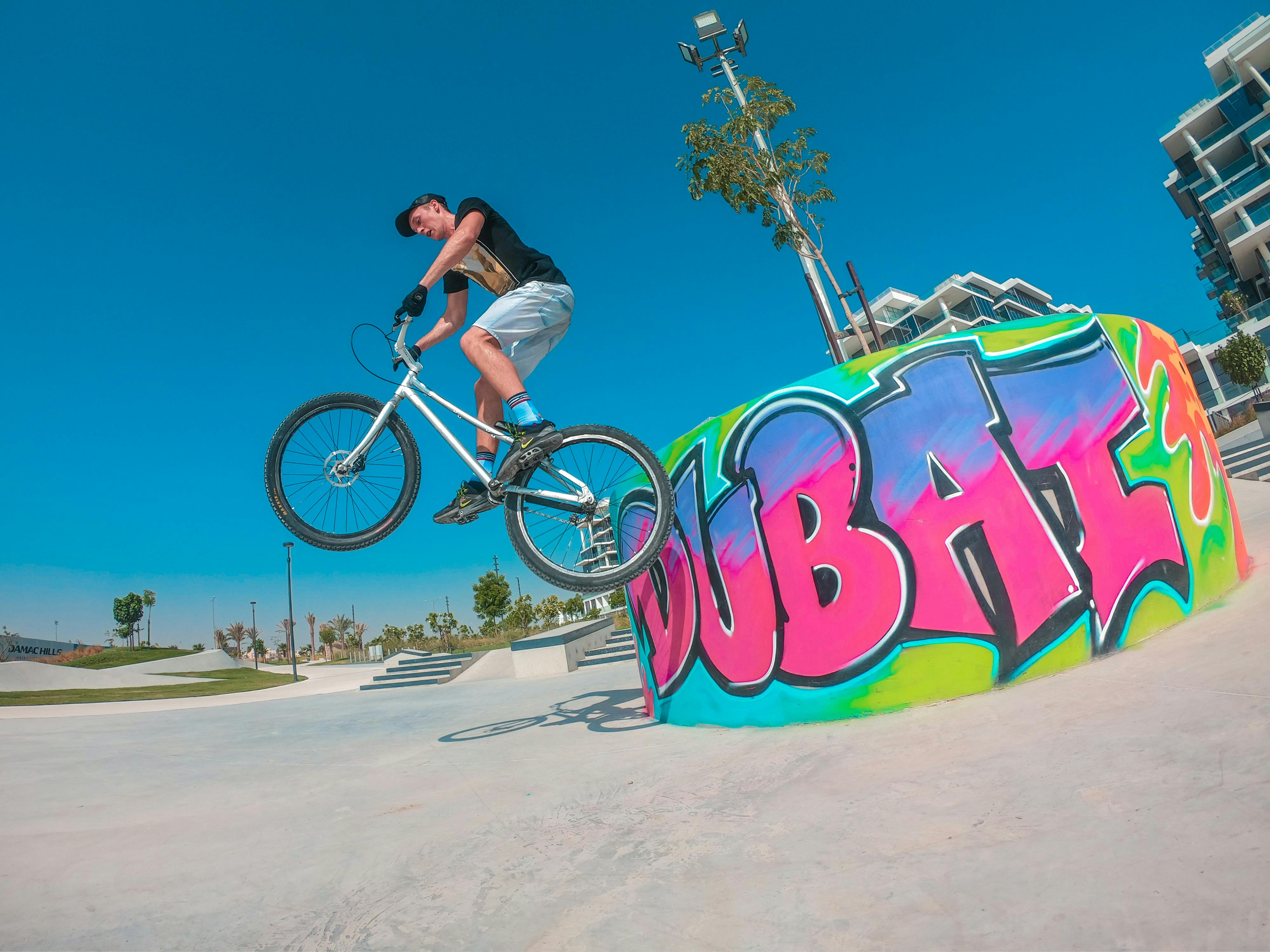 Sportsman jumping with bicycle while practicing freestyle cycling ...