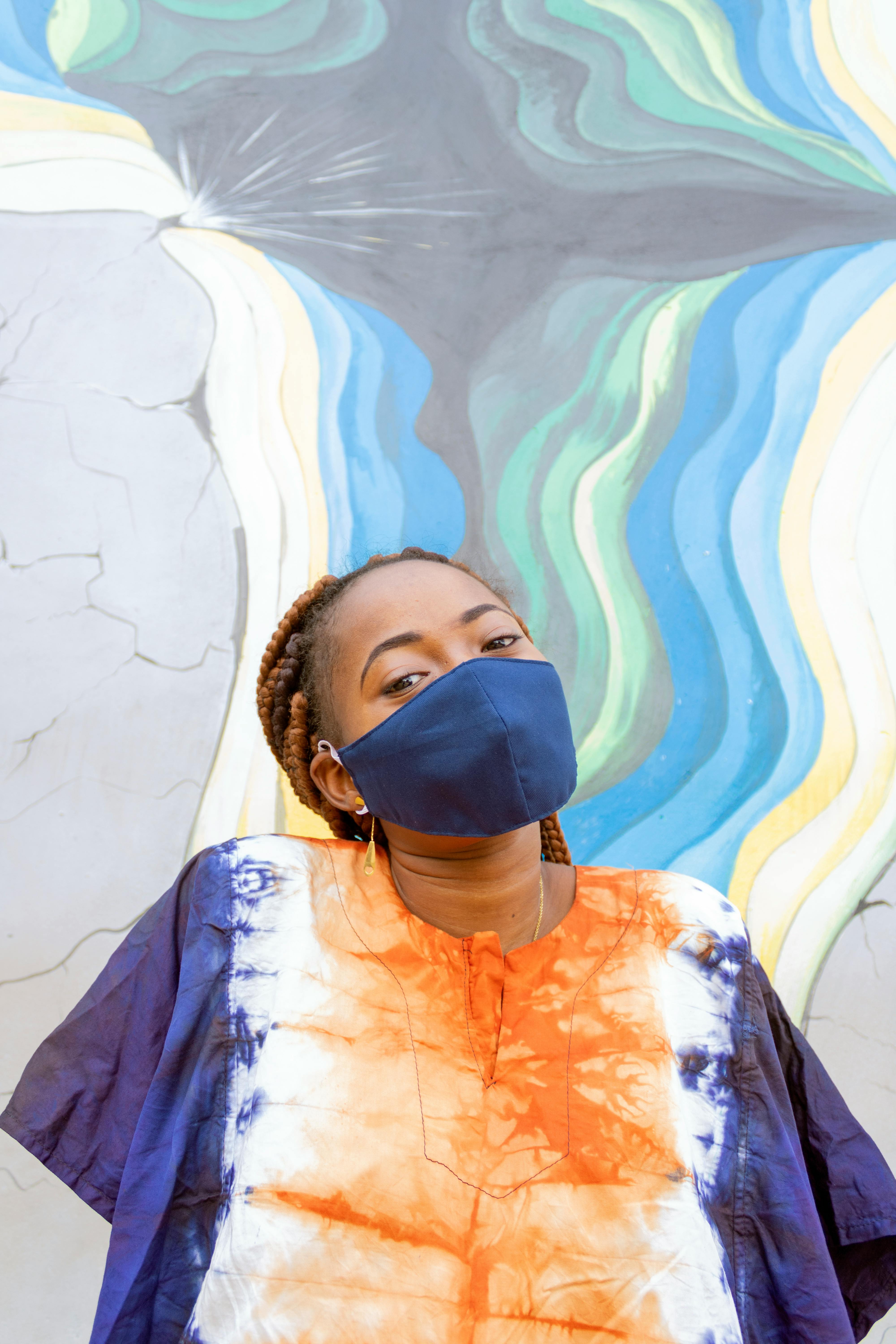 Unrecognizable African American with in face mask resting on street ...