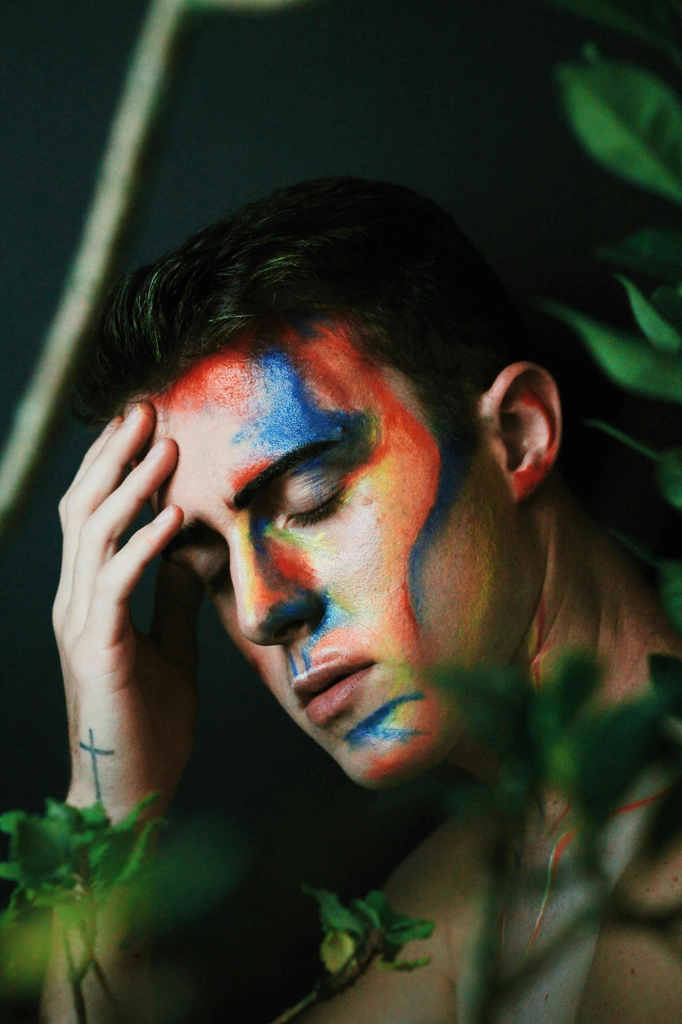 Artistic male model with colorful paints on face in studio · Free Stock ...