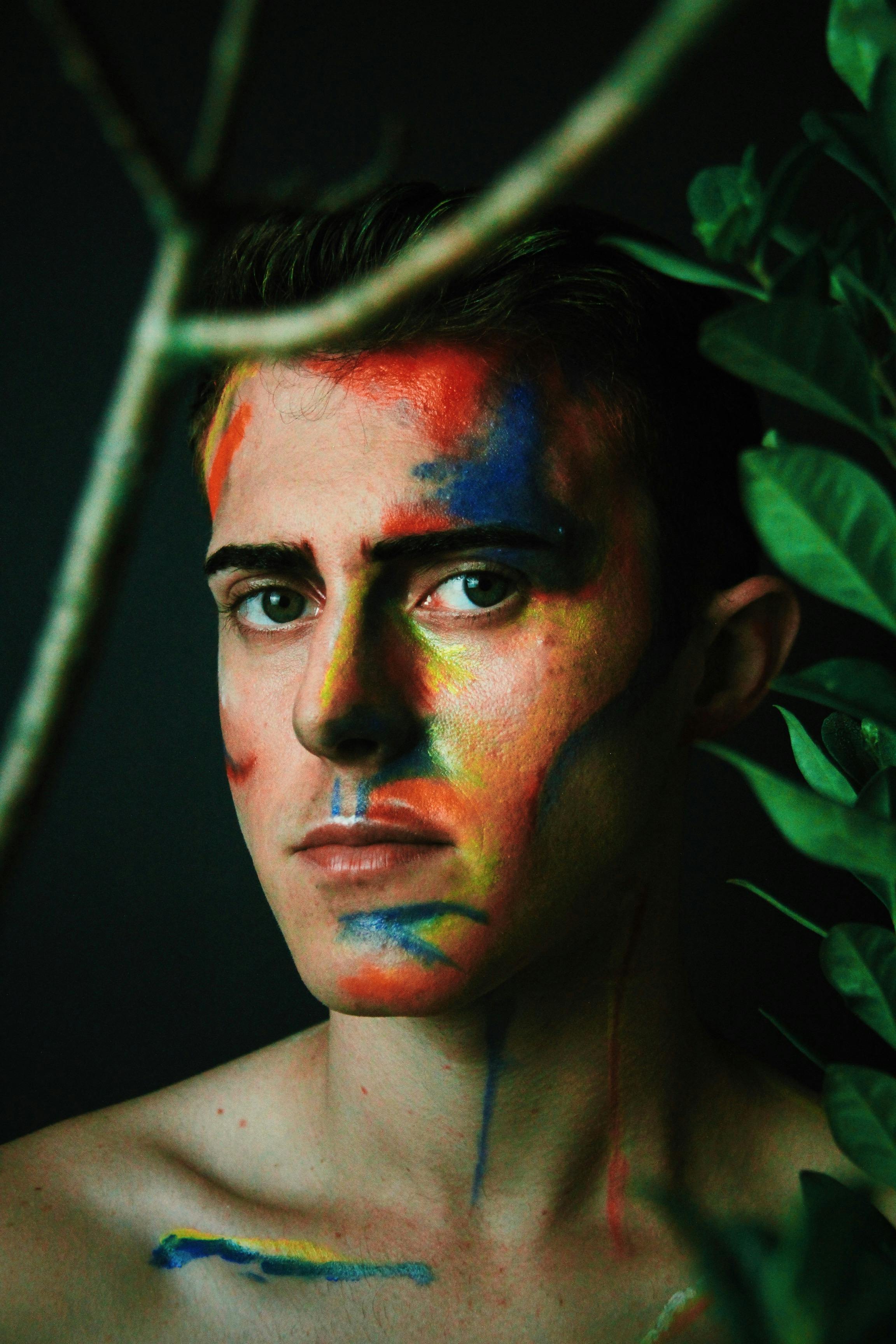 Artistic male model with colorful paints on face in studio · Free Stock ...