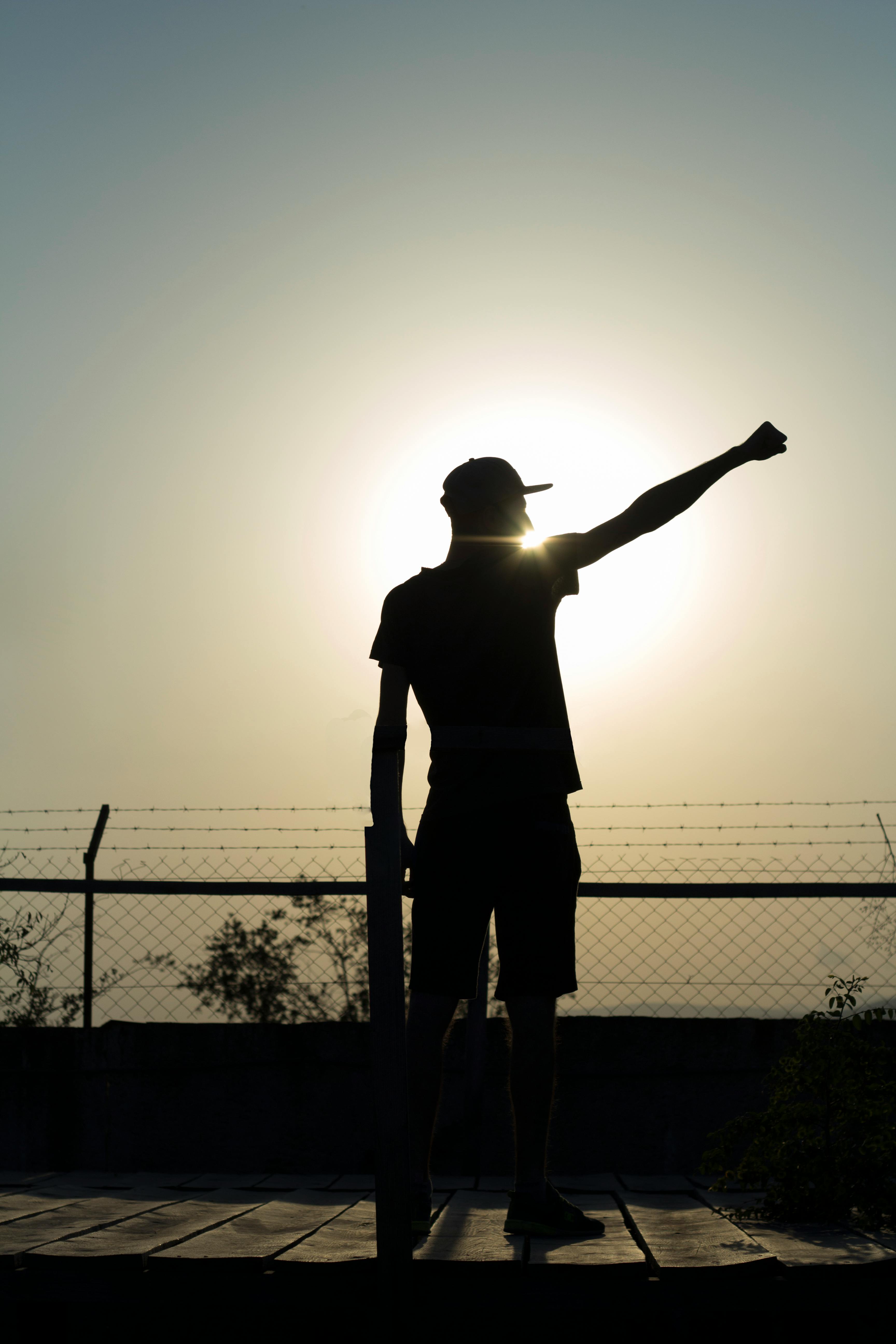 Silhouette of Man Raising His Hands · Free Stock Photo