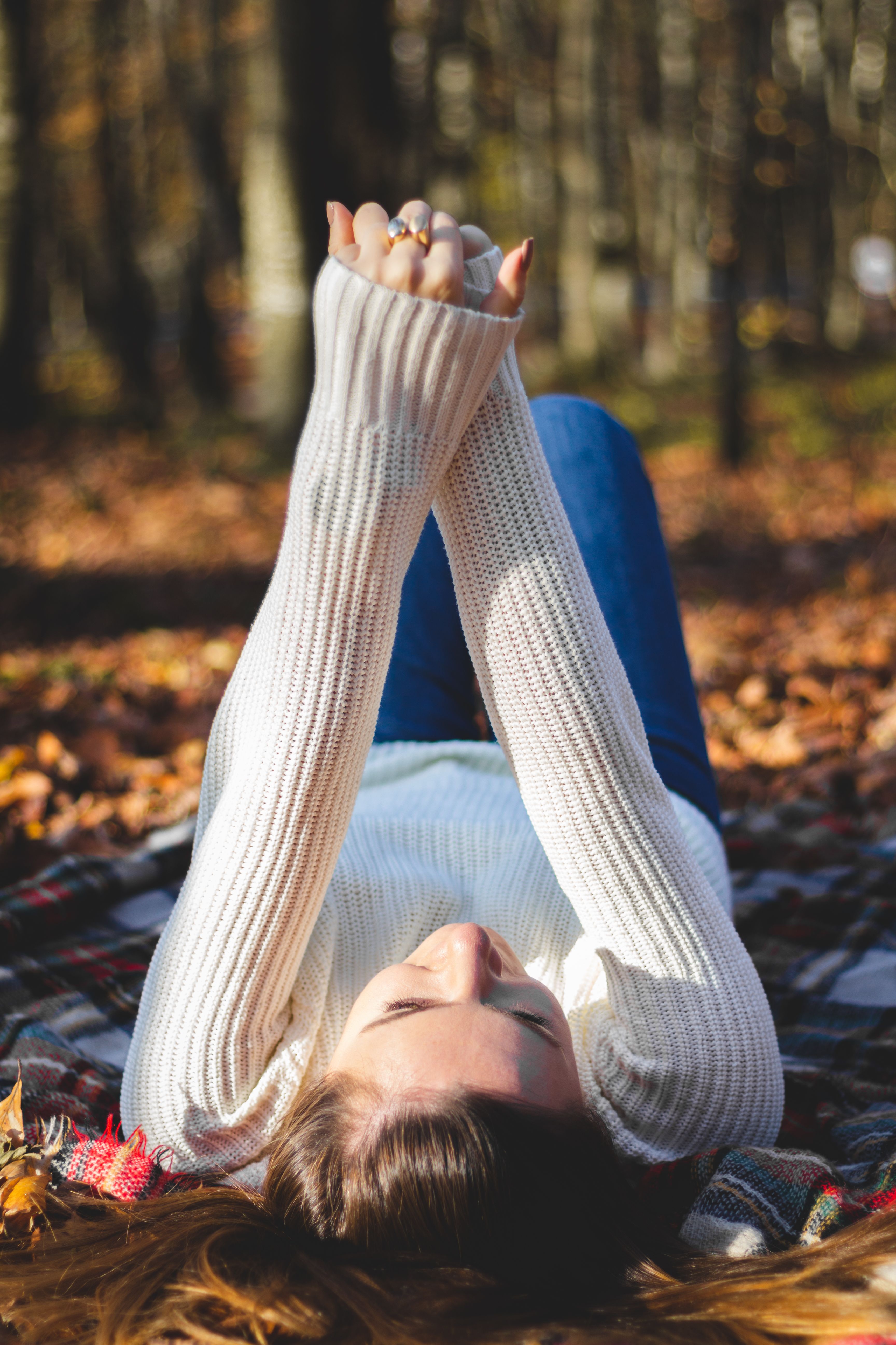 A Woman Lying Down on the Ground with Outstretched Hands · Free Stock Photo
