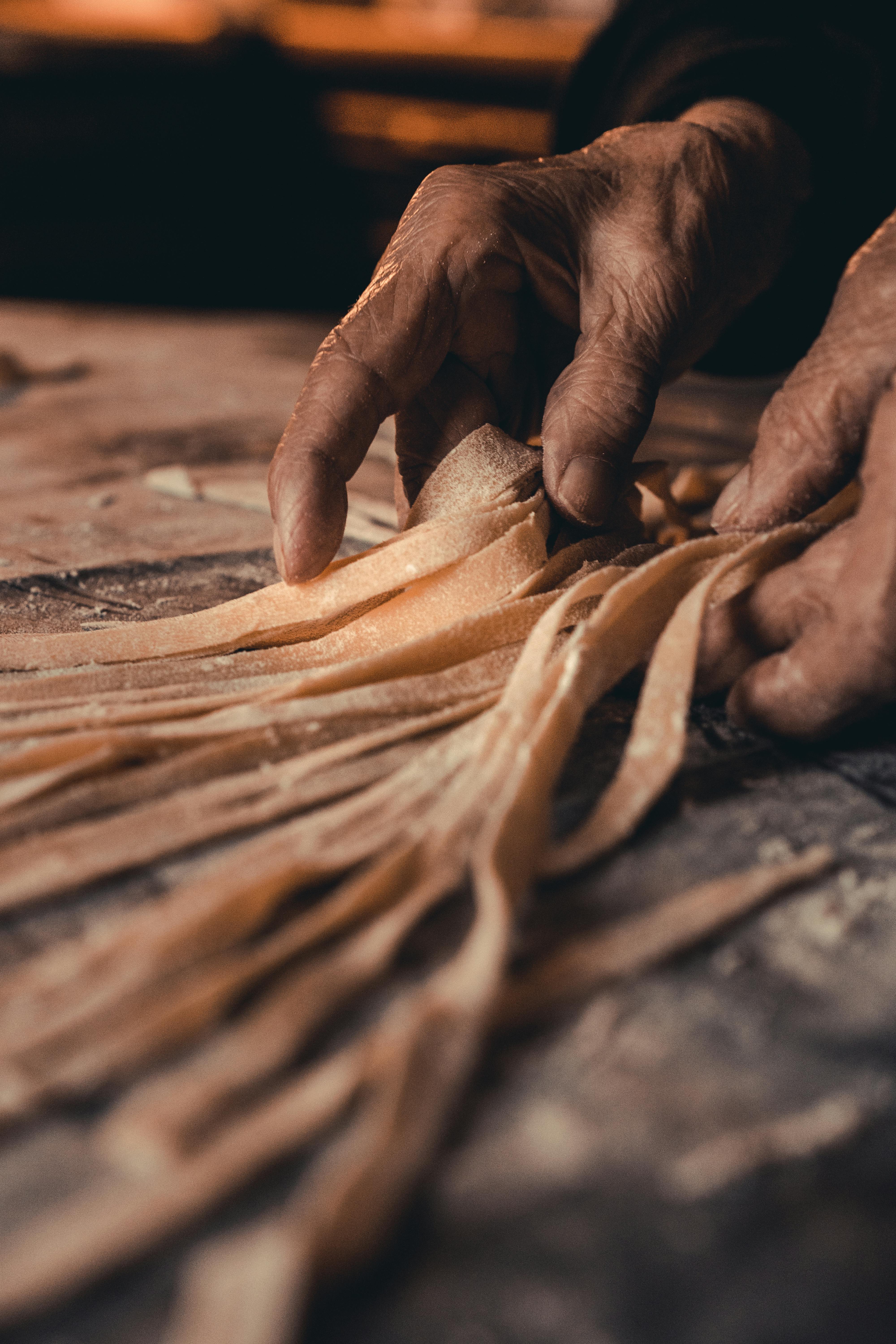 Wrinkly Hands of a Person Holding Uncooked Pasta · Free Stock Photo