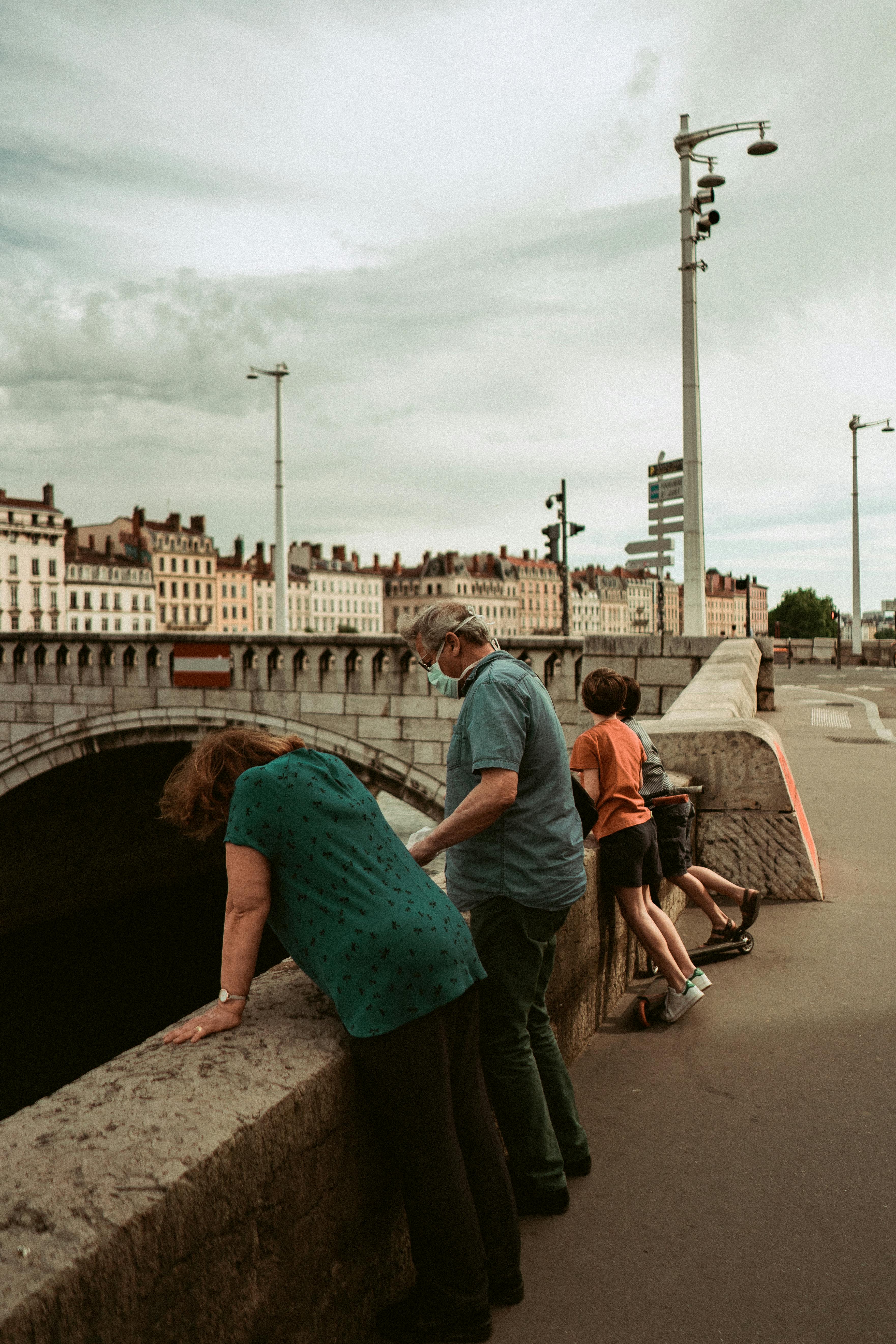 People Standing Near a Concrete Barrier and Arched Bridge · Free Stock ...