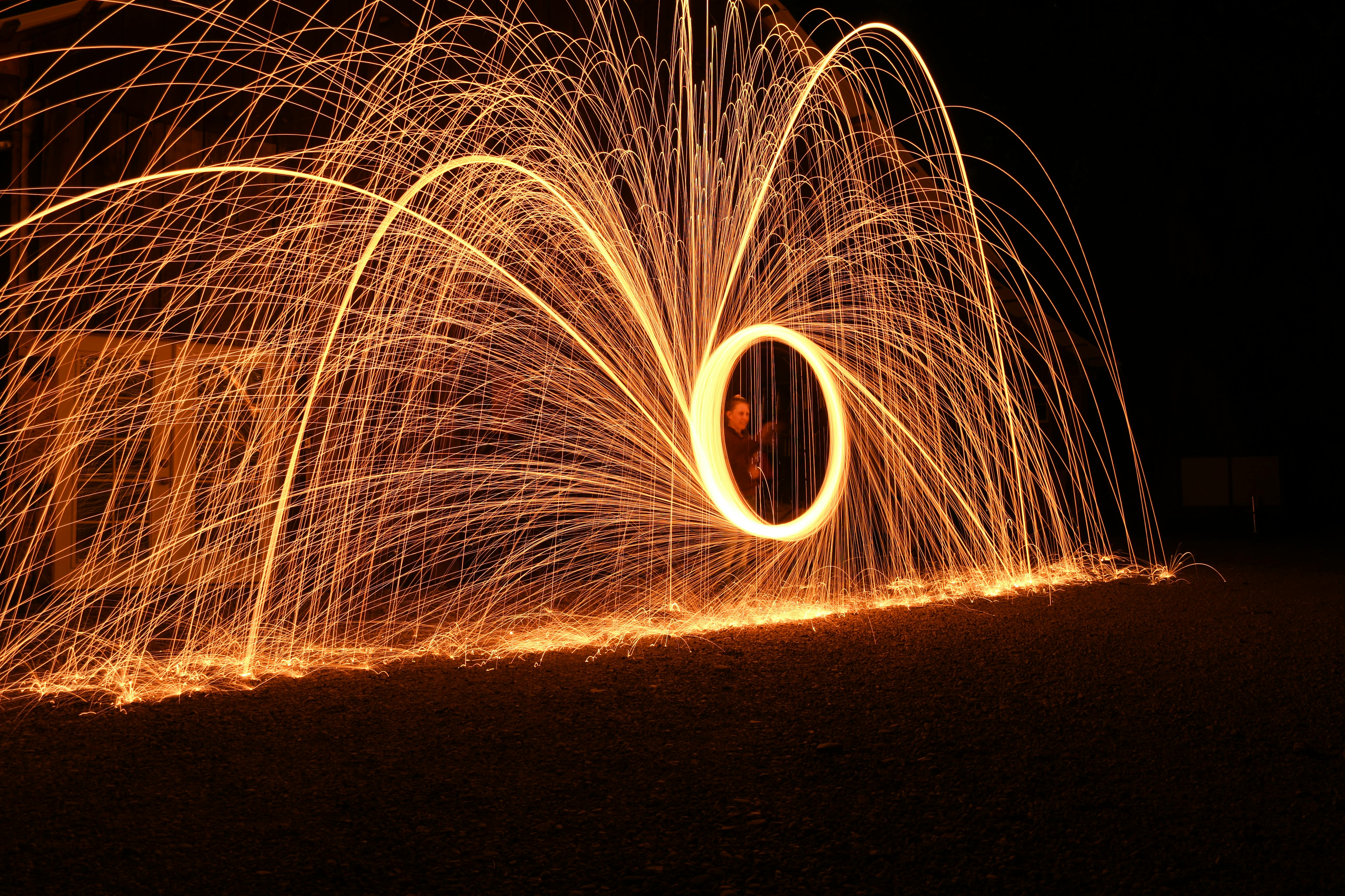 Woman Standing Behind an Illuminated Spinning Fireworks · Free Stock Photo
