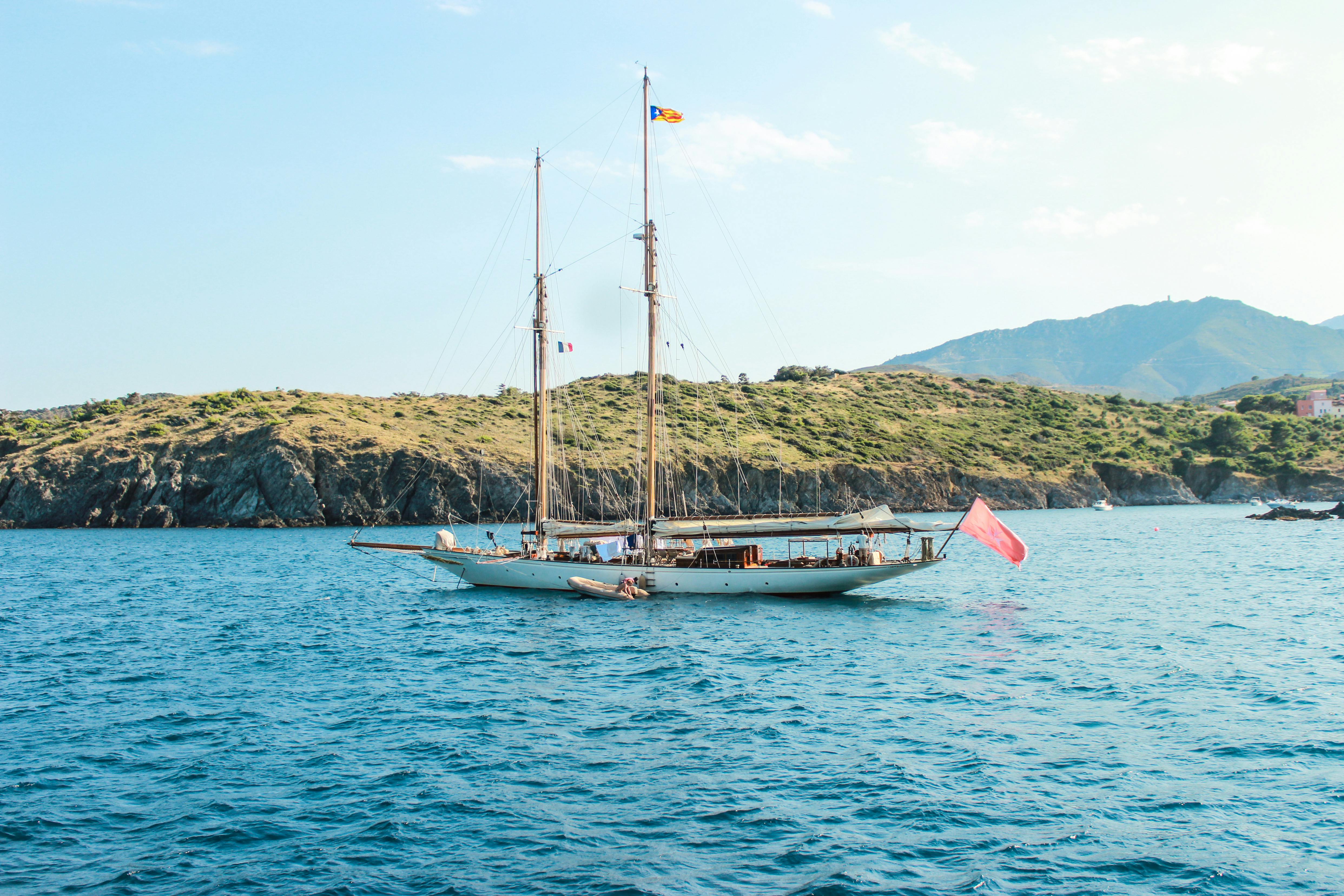 Sailboat in sea near shoreline · Free Stock Photo