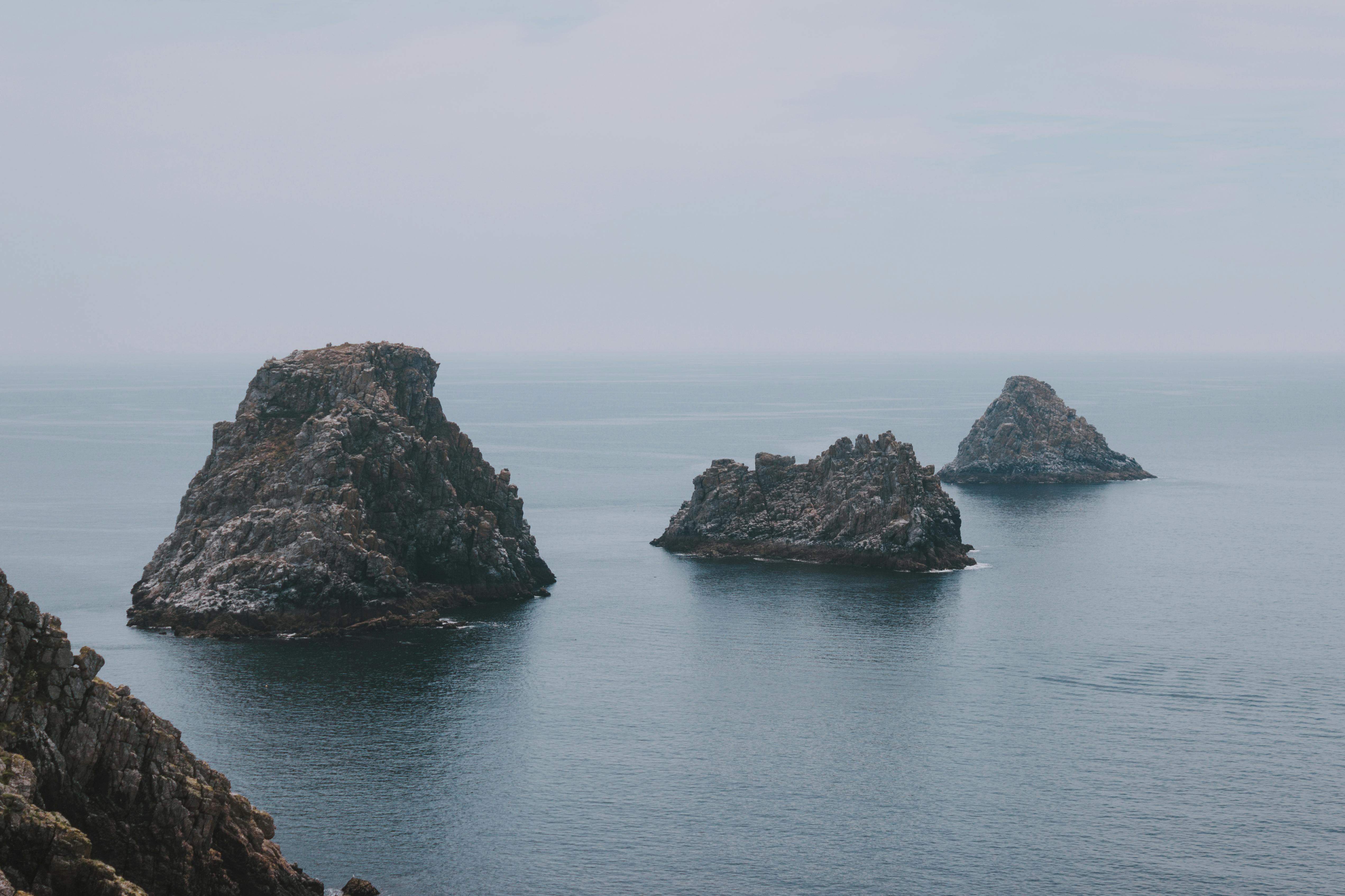 Cliff and islands near shore of ocean · Free Stock Photo