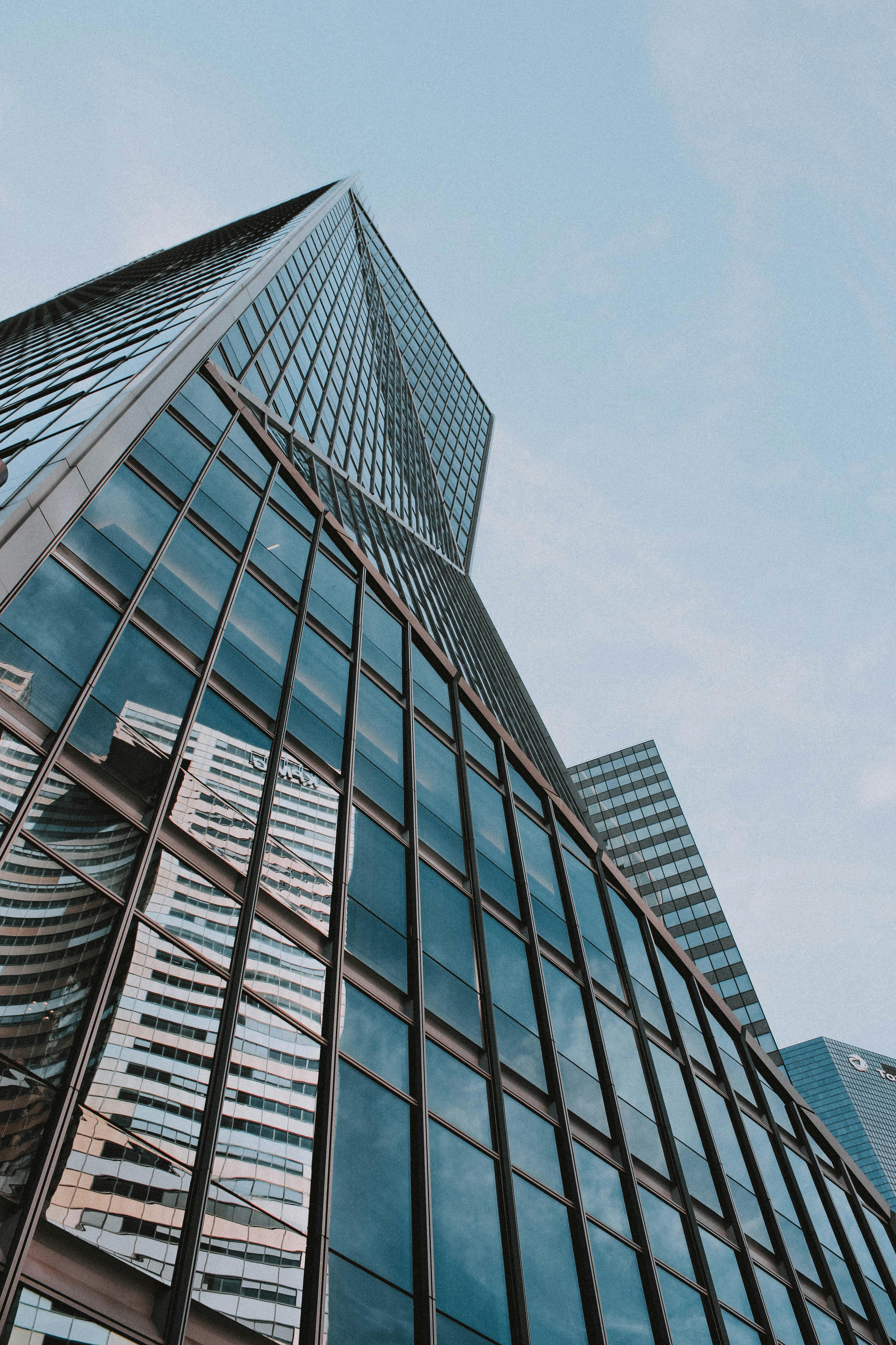 Modern geometric skyscraper with glass walls · Free Stock Photo