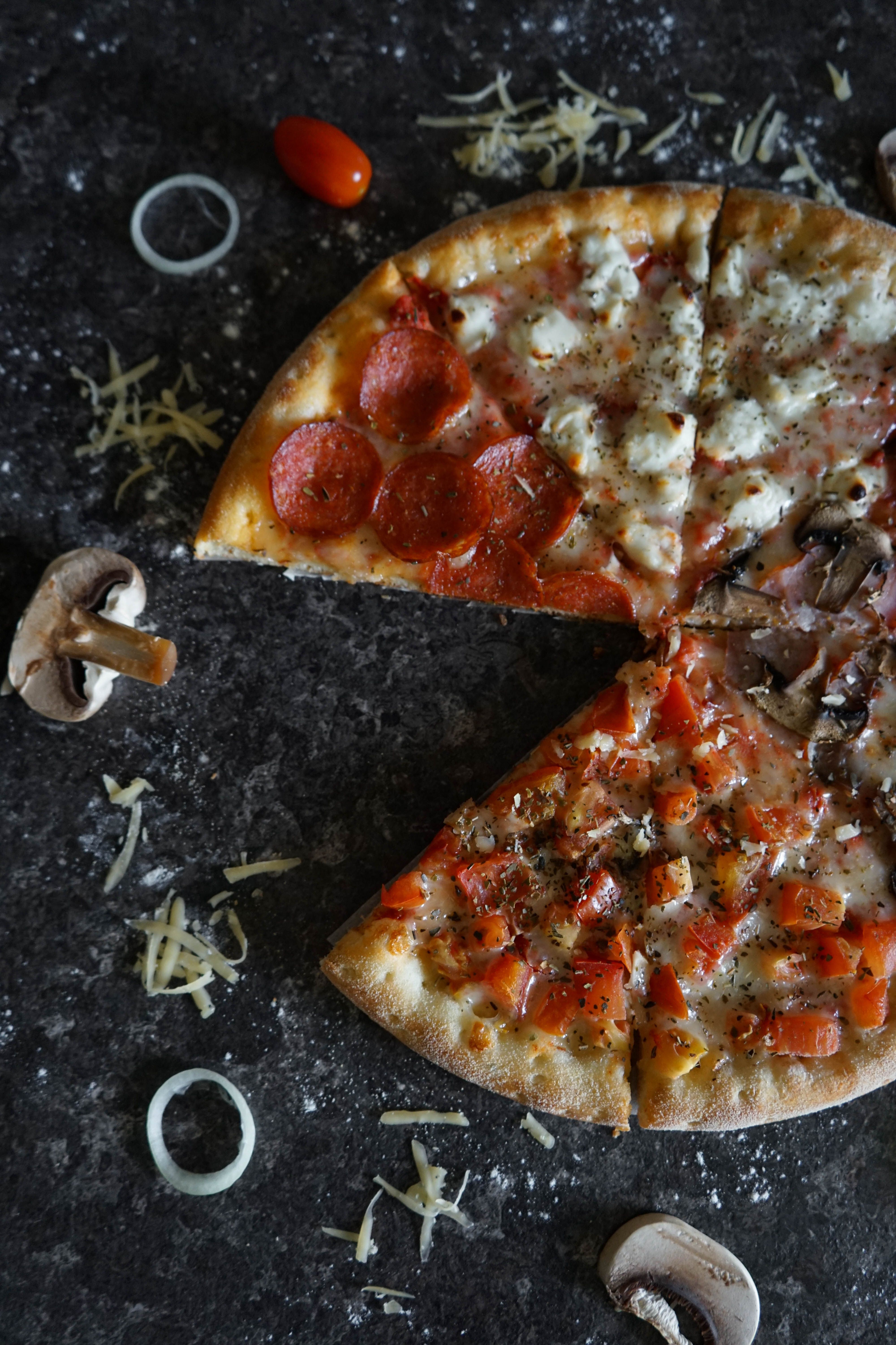 Yummy assorted pizza on table in kitchen · Free Stock Photo