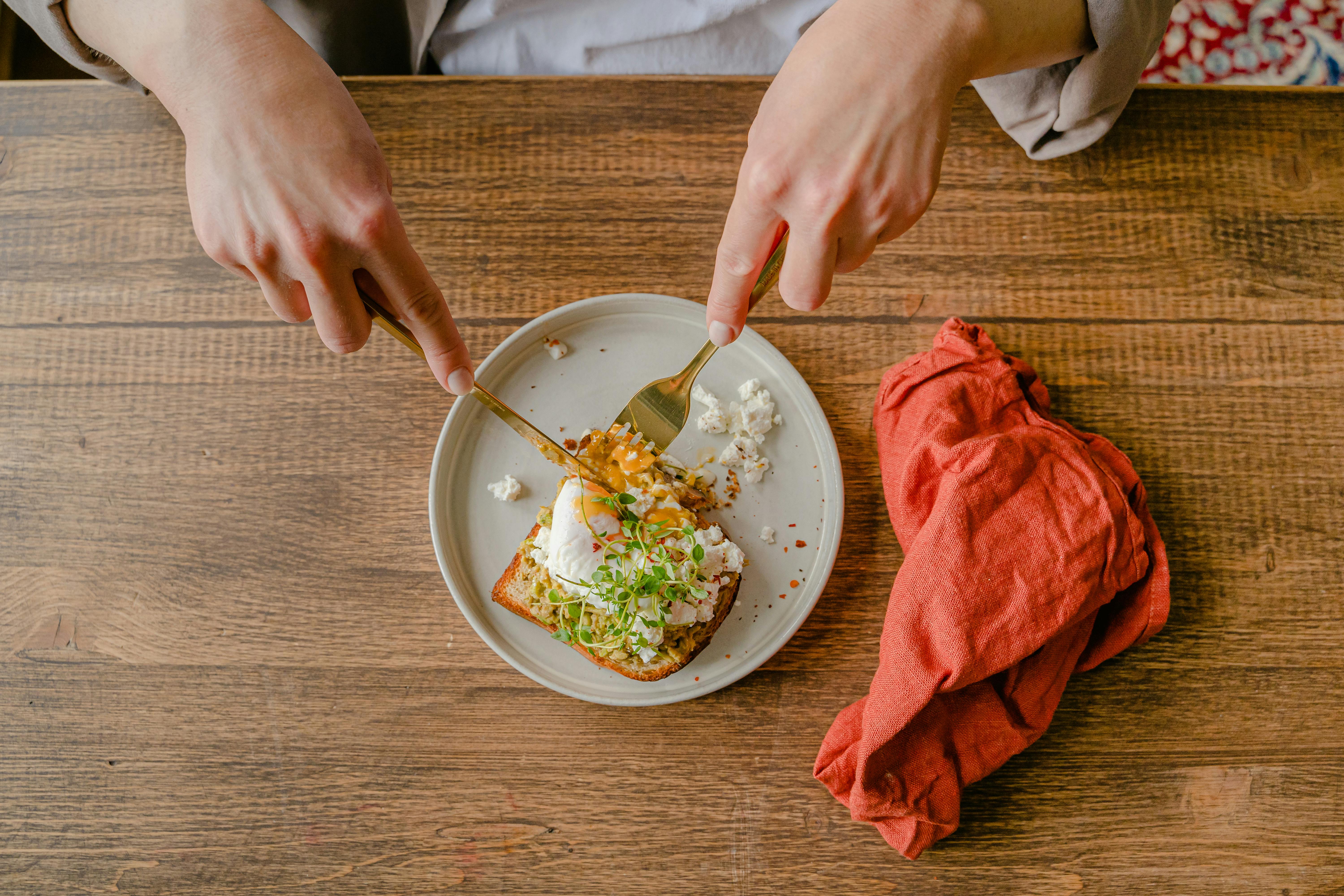 A Person Eating a Toast with Boiled Egg · Free Stock Photo