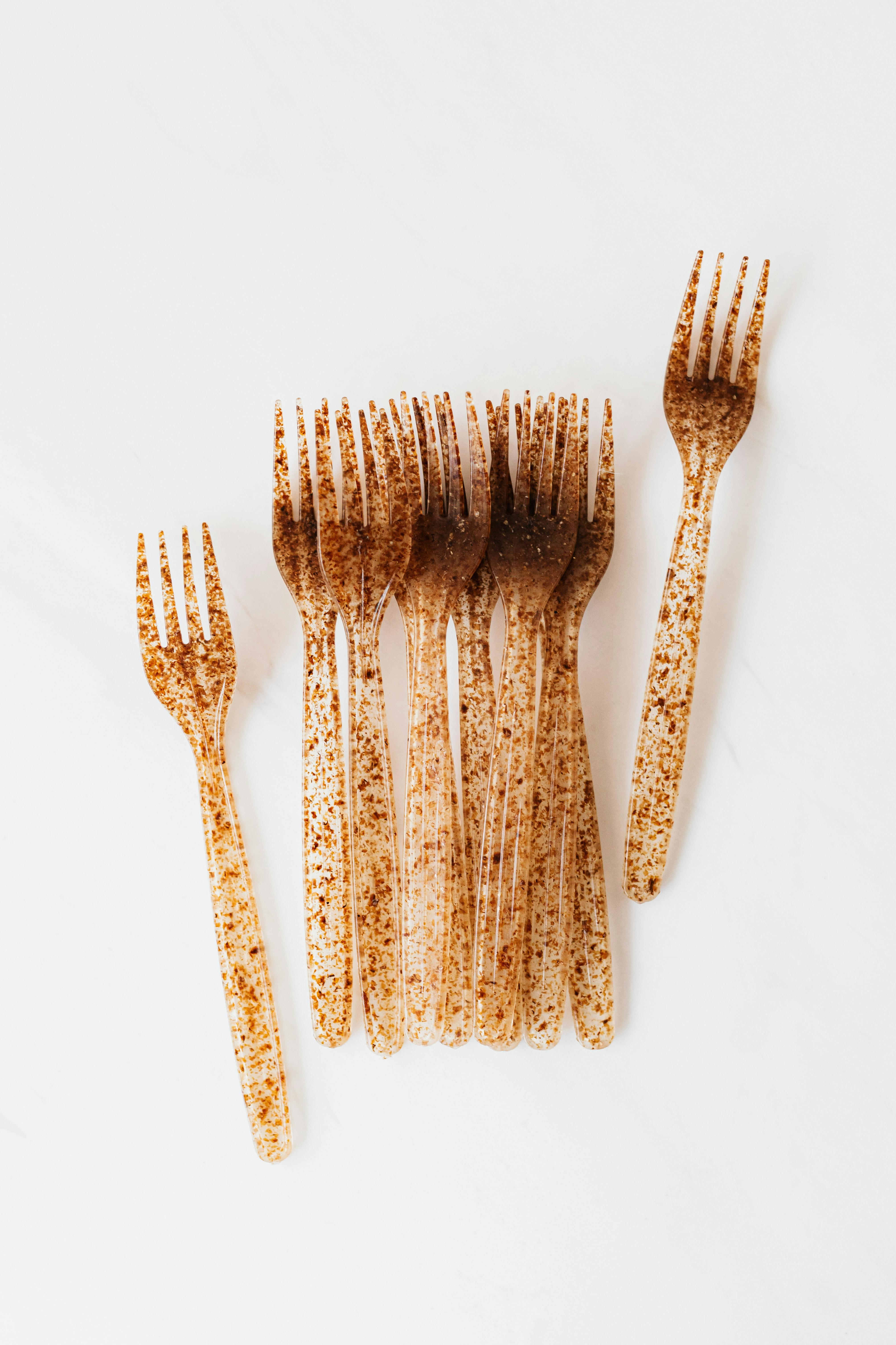 Pile of plastic forks on white table · Free Stock Photo