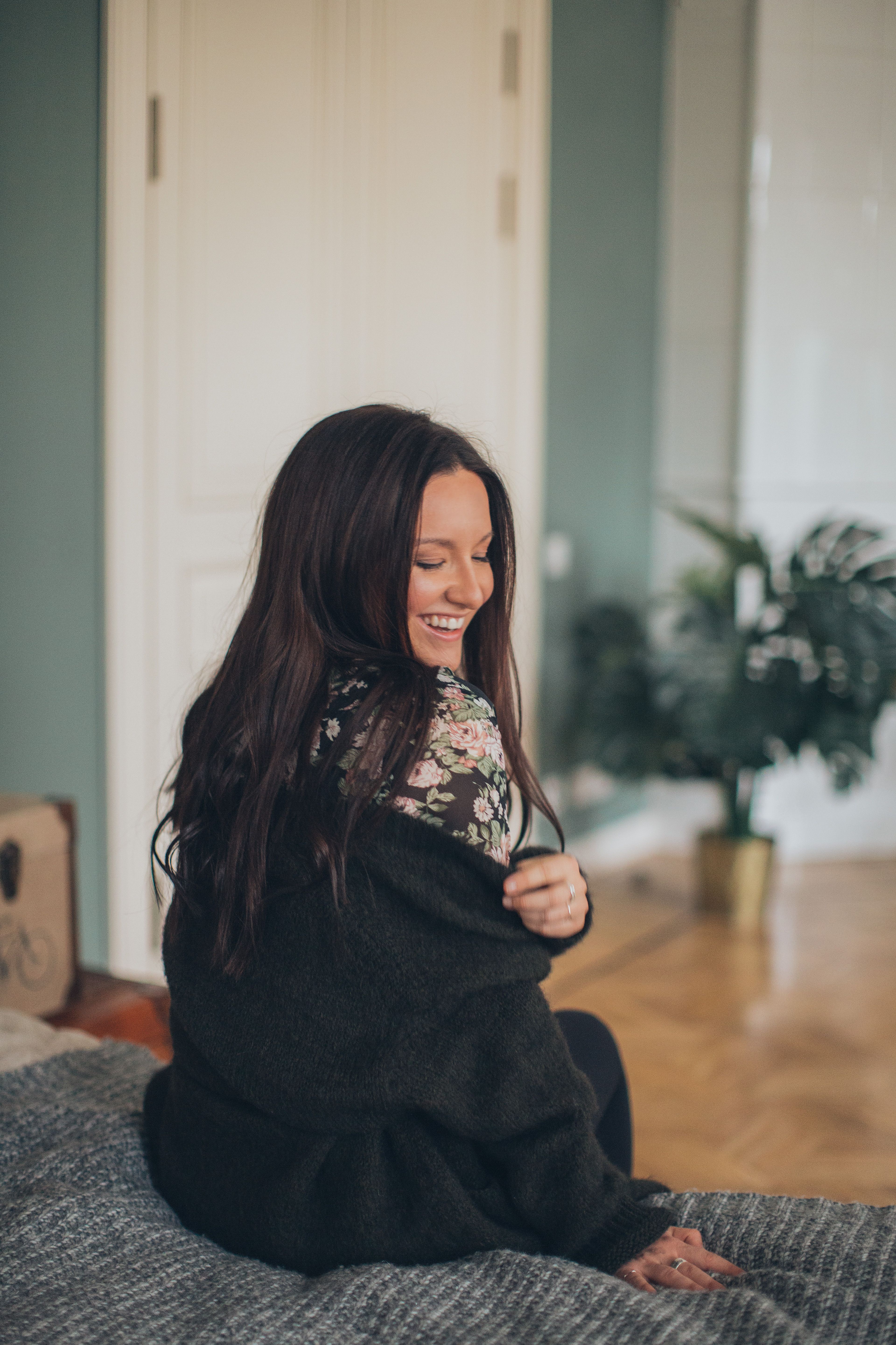 A Woman in Black Cardigan Sitting on a Bed · Free Stock Photo