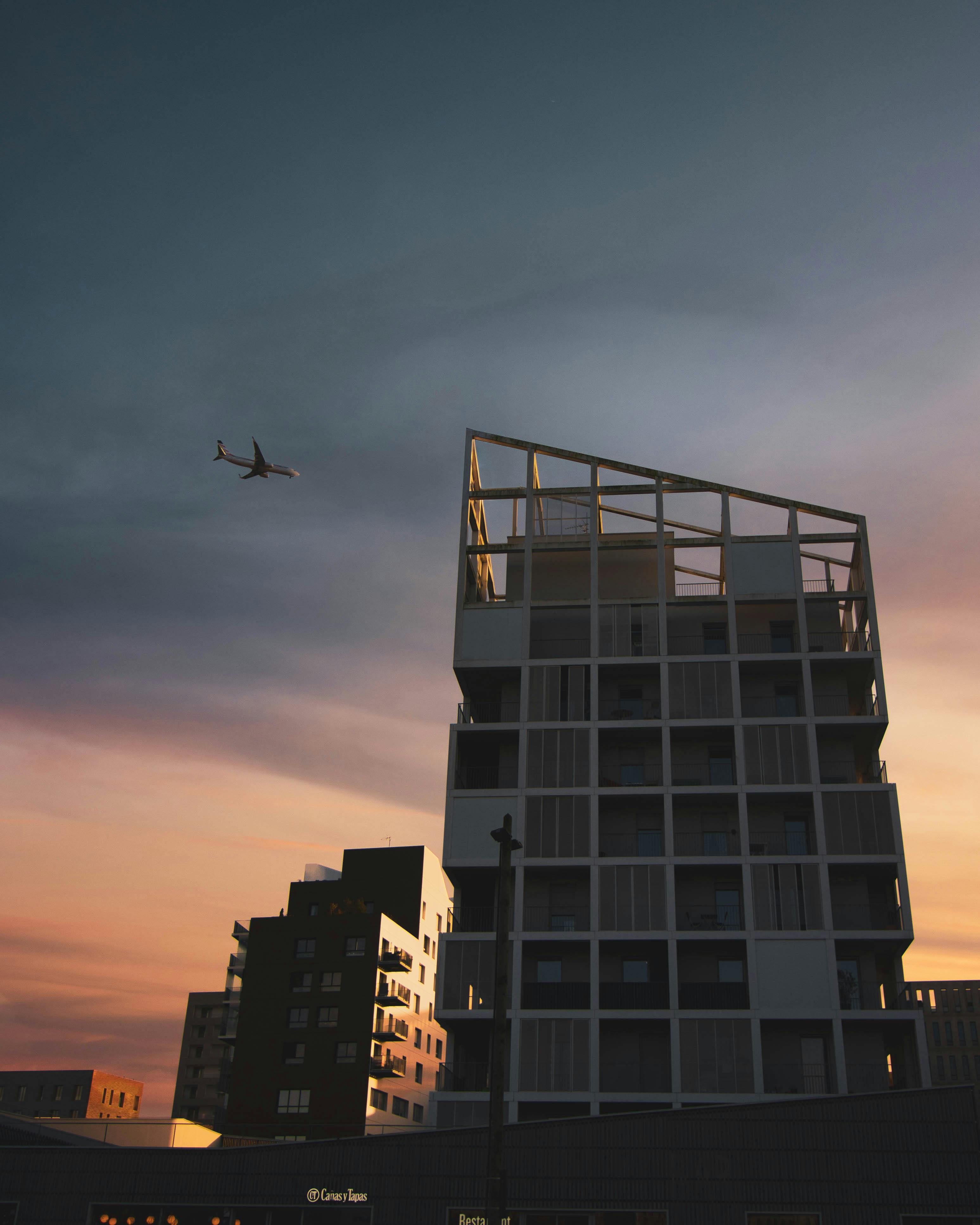 Airplane Flying Over City Buildings · Free Stock Photo