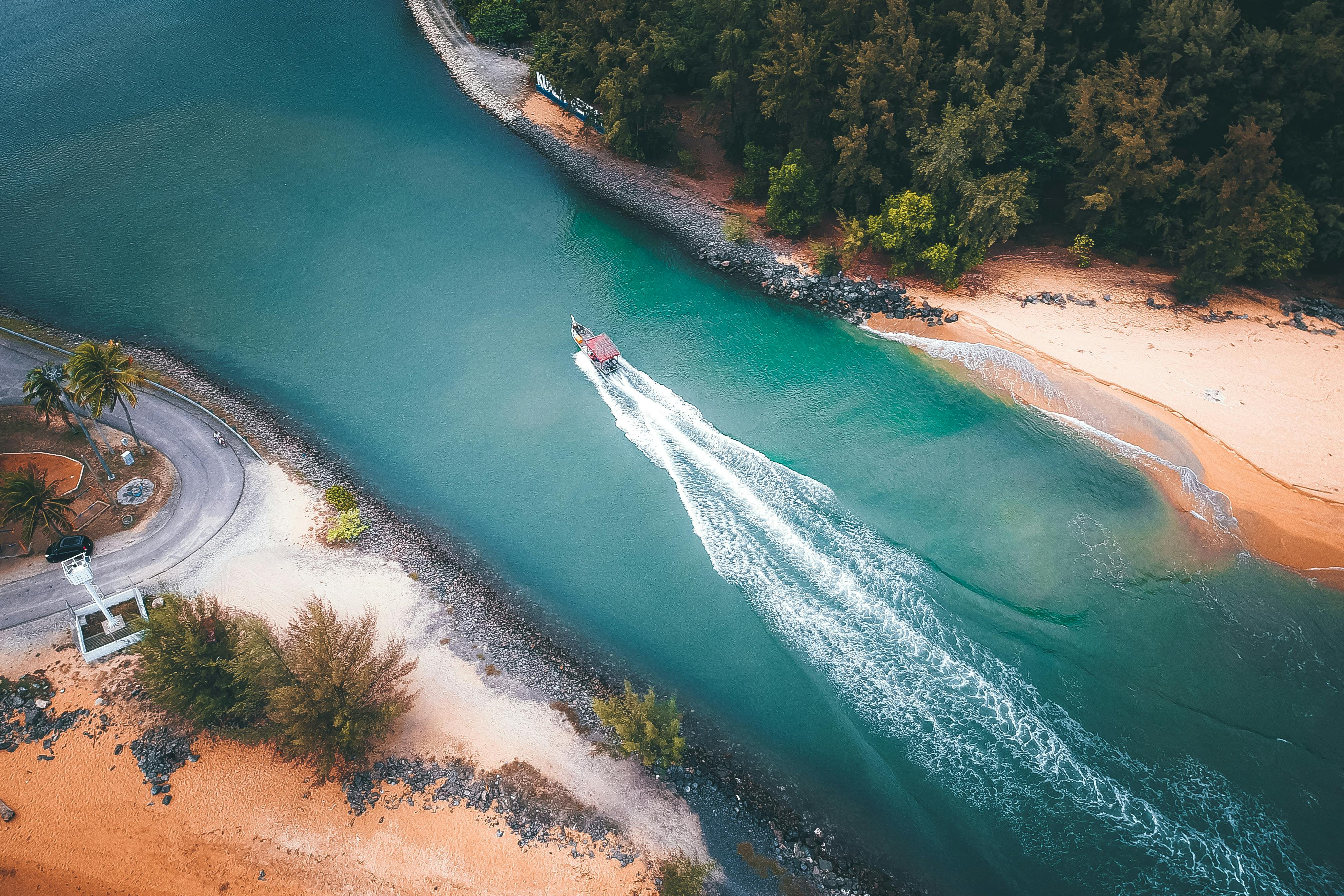 Motorboat floating near seashore on sunny day · Free Stock Photo