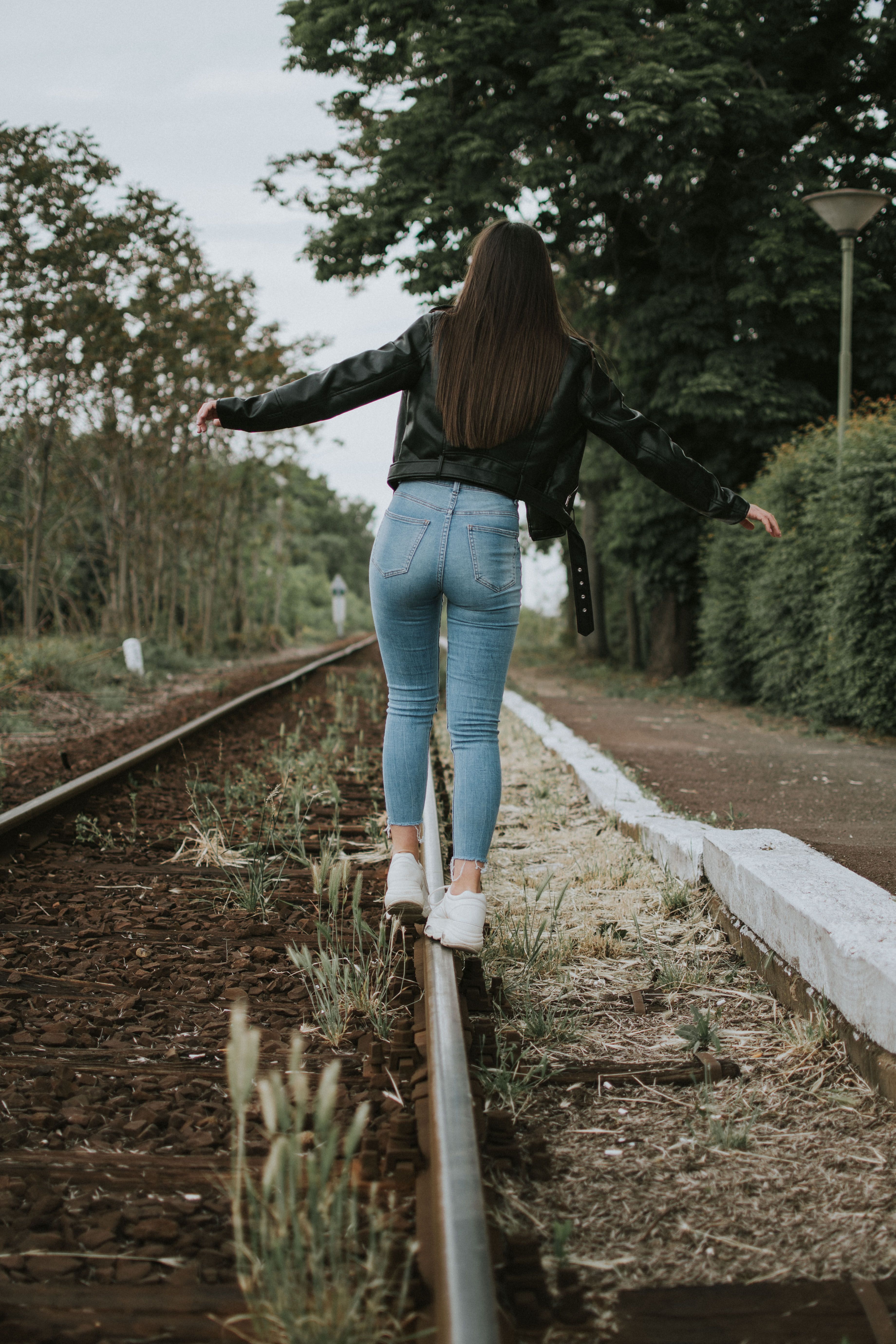 Back View of a Woman Balancing on the Side of the Dock · Free Stock Photo