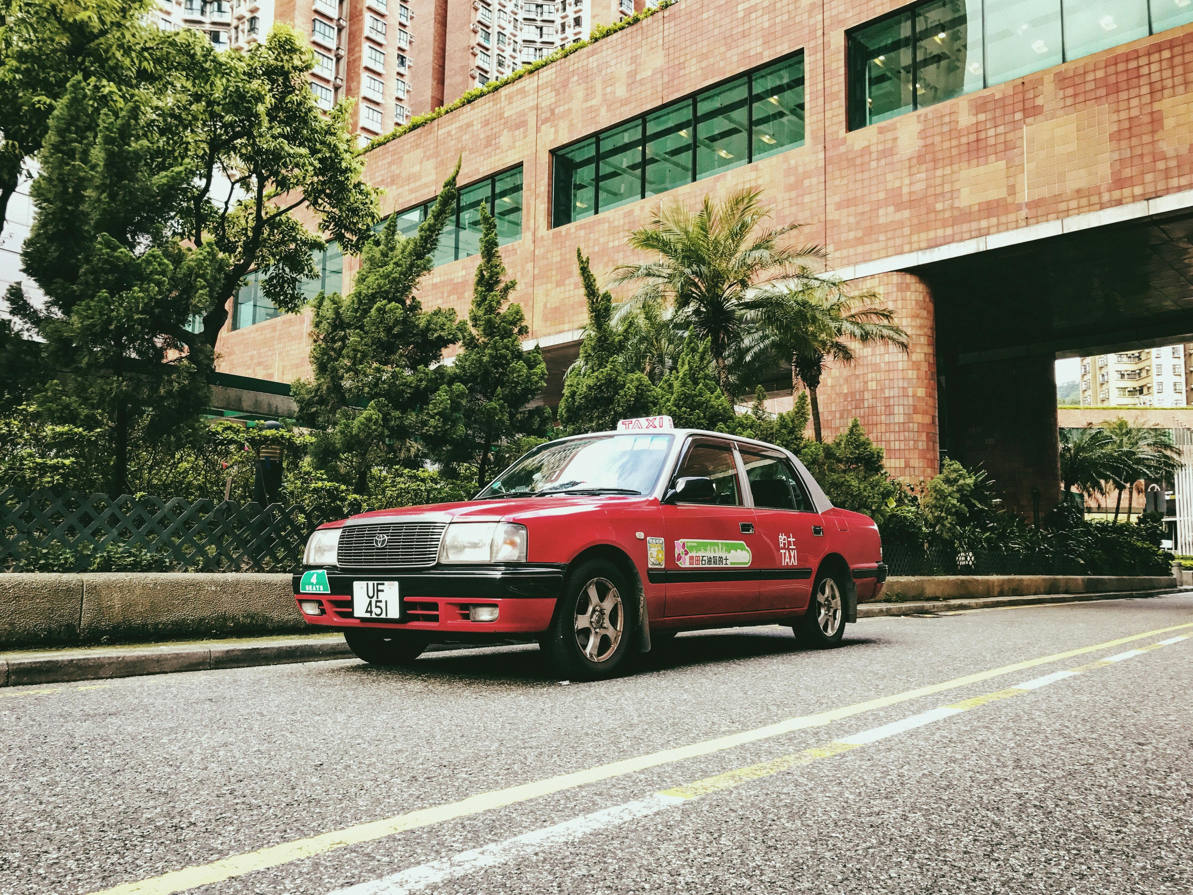 Retro taxi car on asphalt road near city buildings · Free Stock Photo