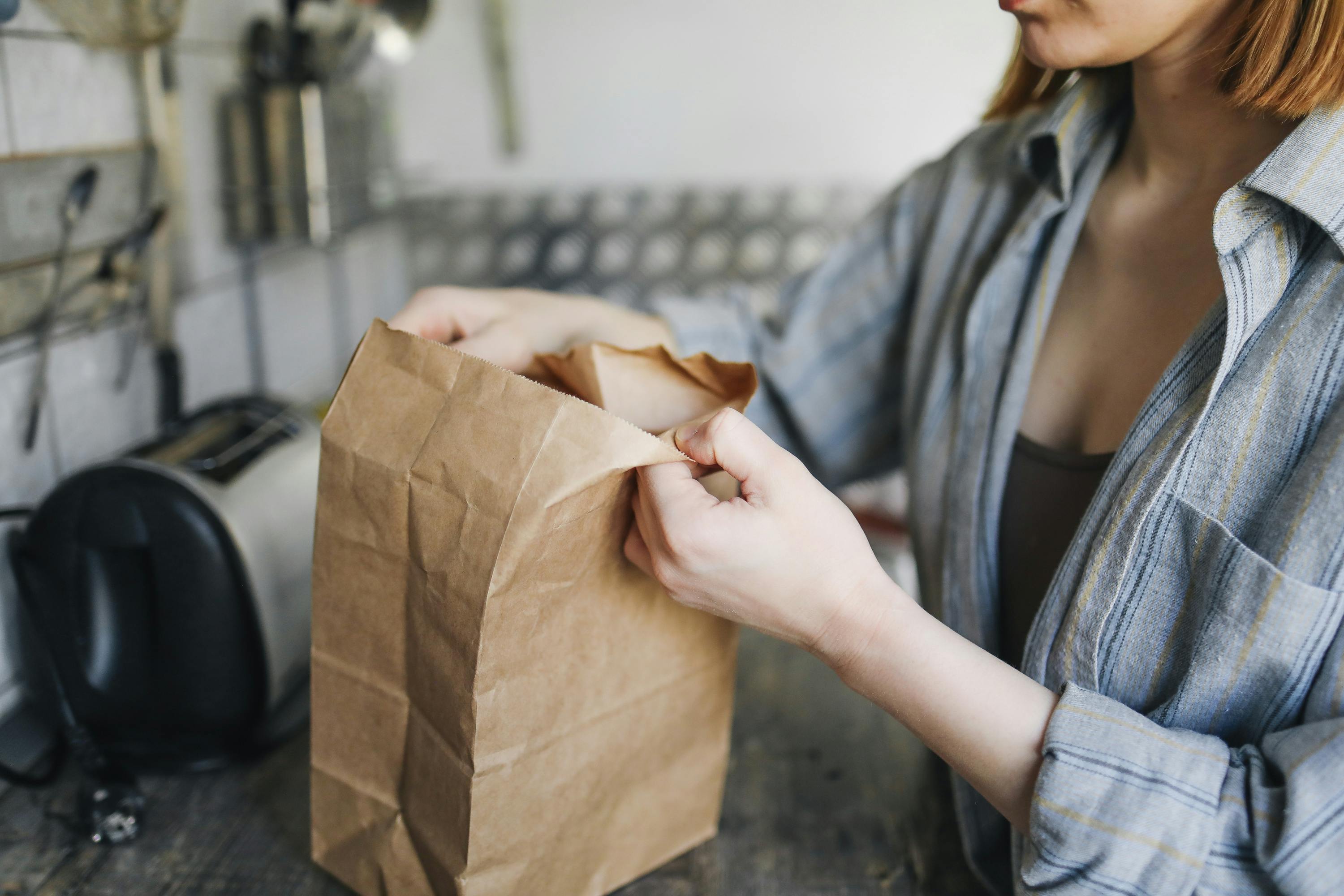 A Woman Opening a Paper Bag · Free Stock Photo