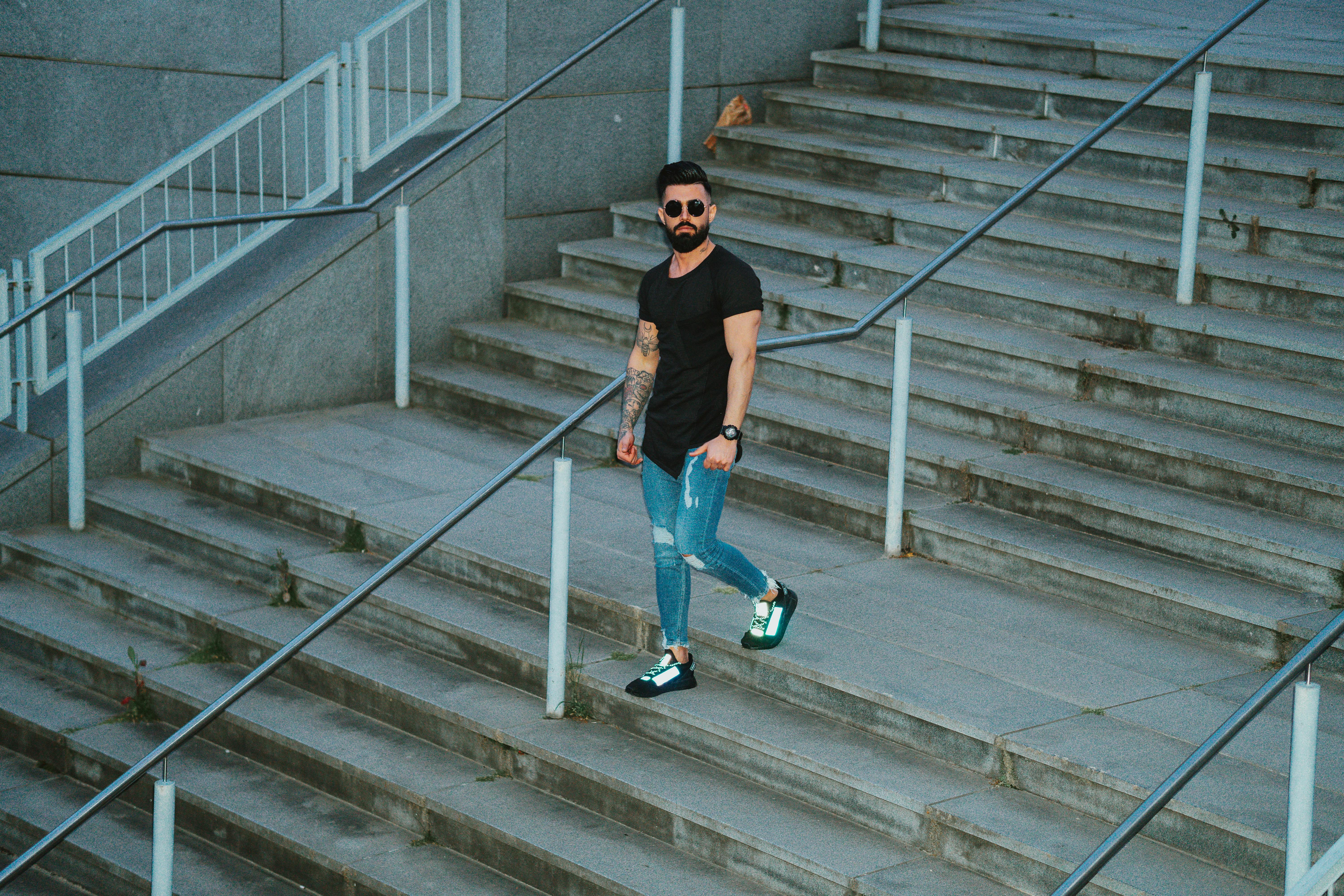 Ethnic male walking downstairs in city · Free Stock Photo