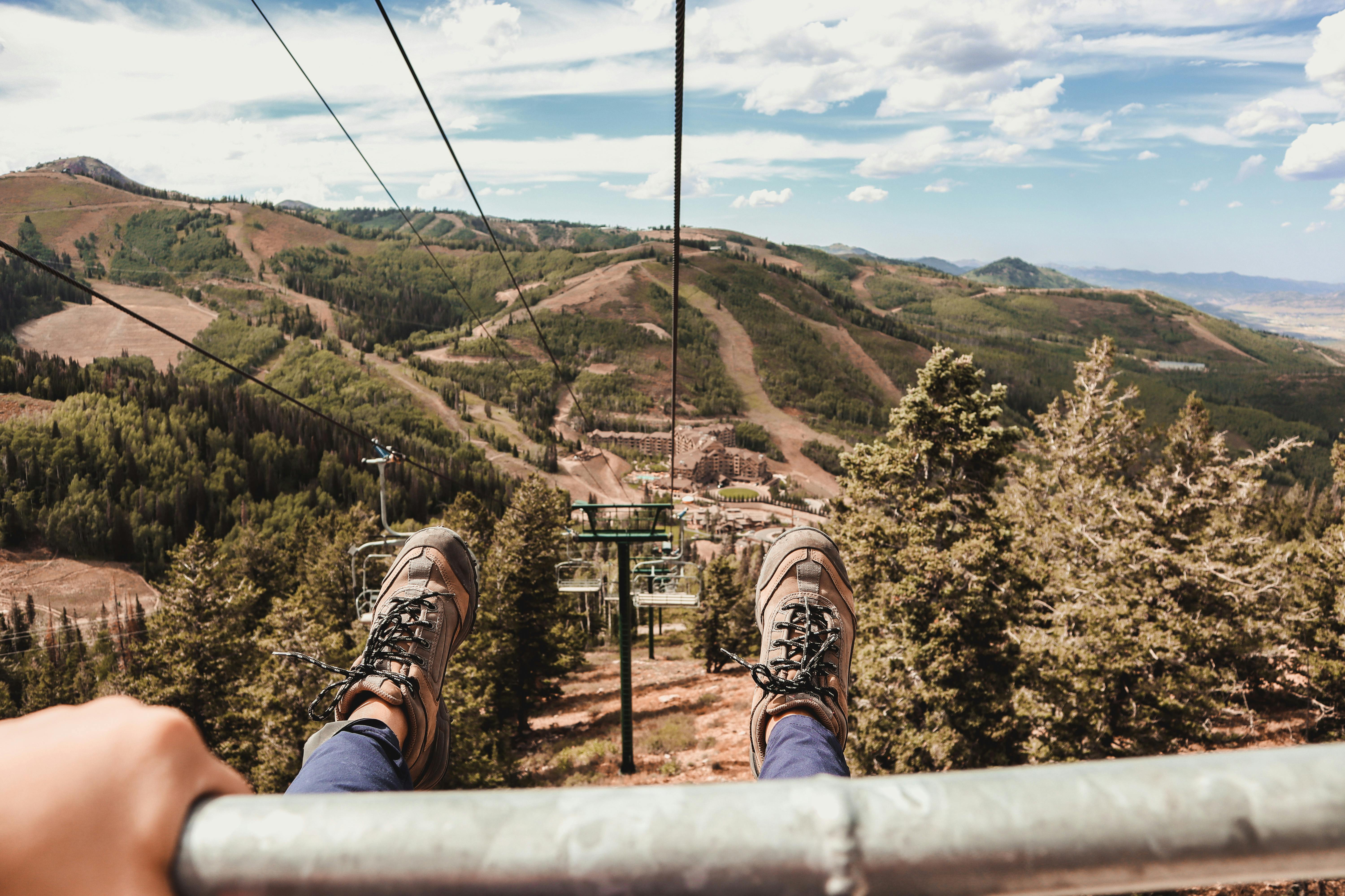 Traveler discovering high terrain on ropeway · Free Stock Photo