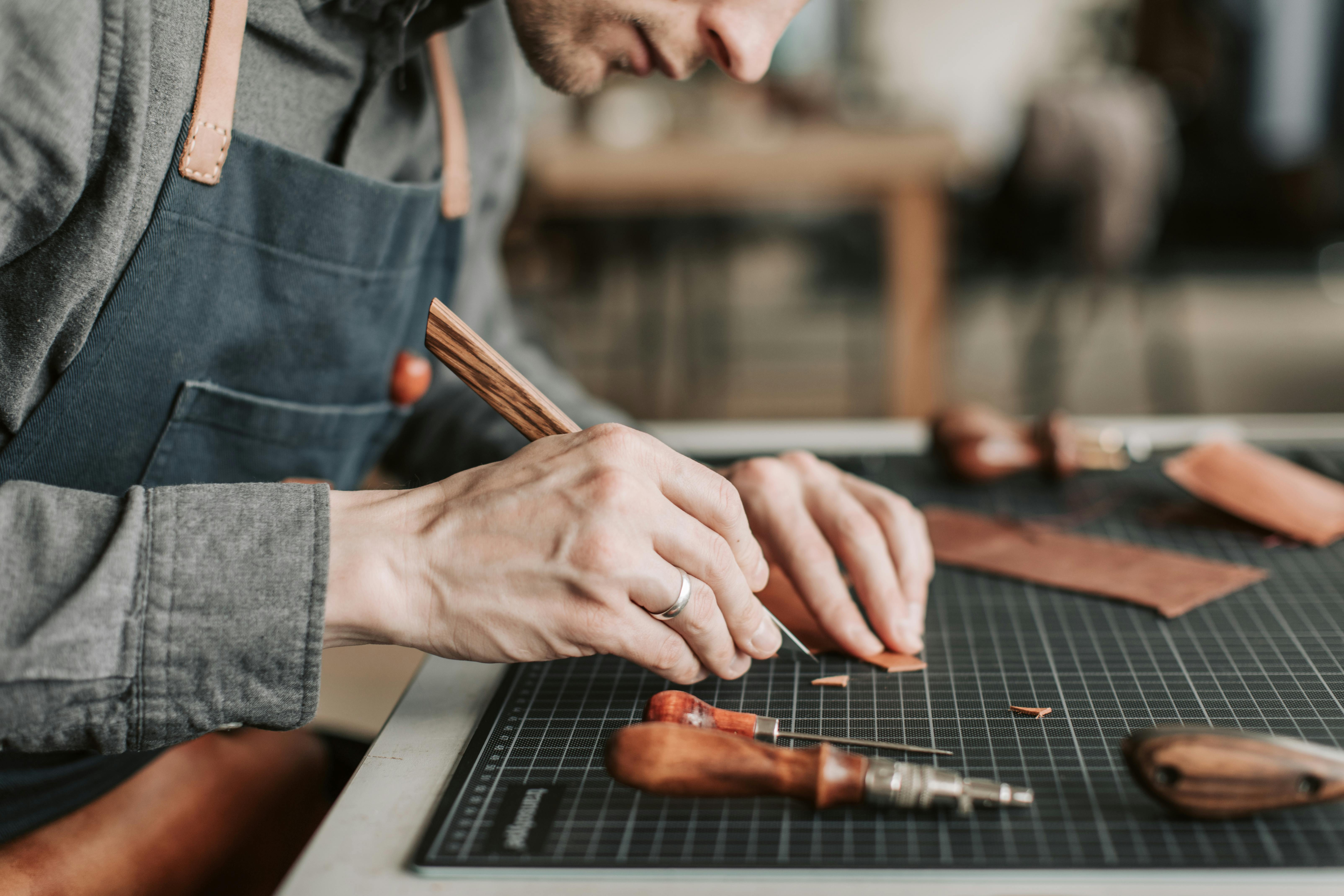 A Person Cutting a Brown Leather · Free Stock Photo