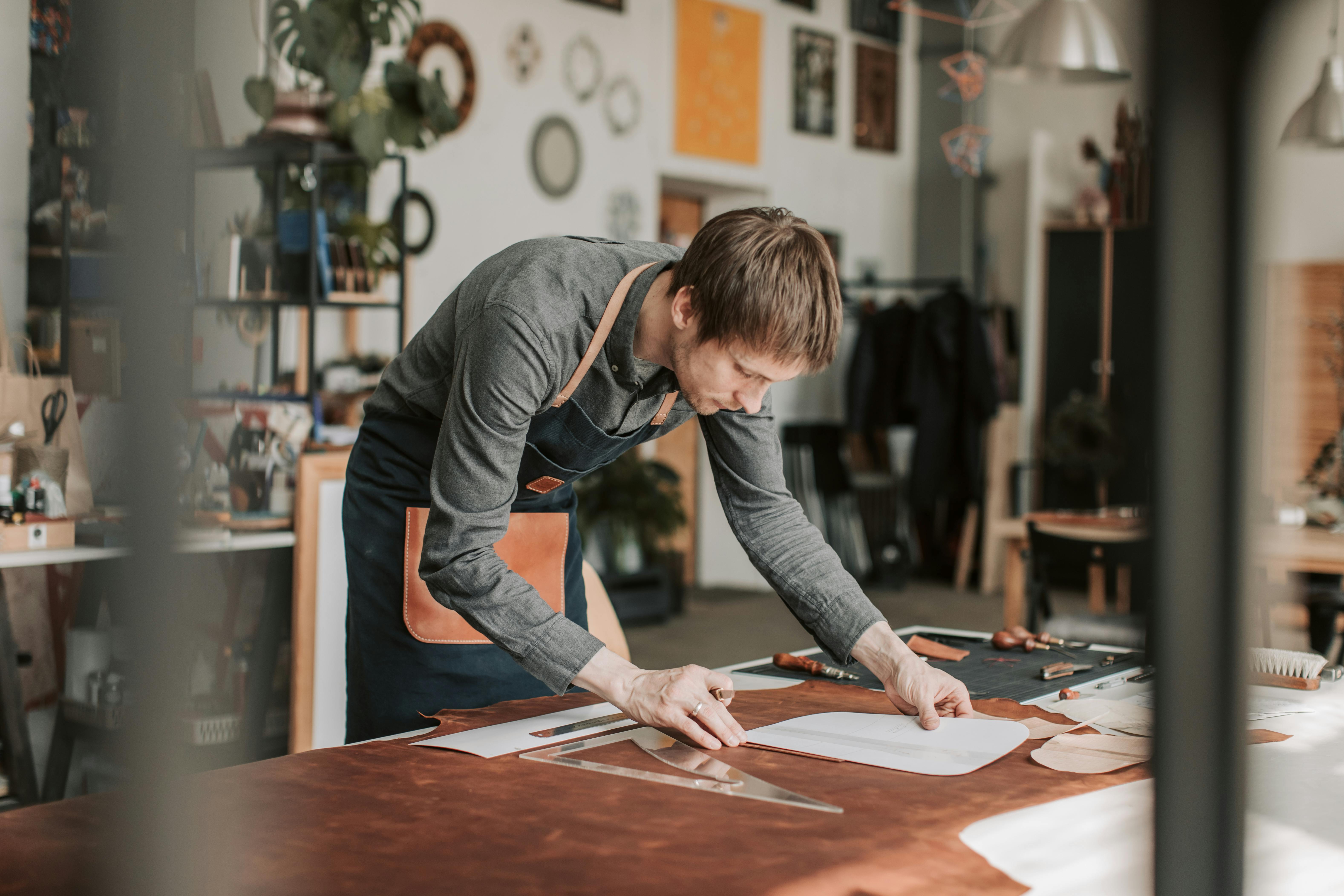 Man Bending over Table and Working · Free Stock Photo