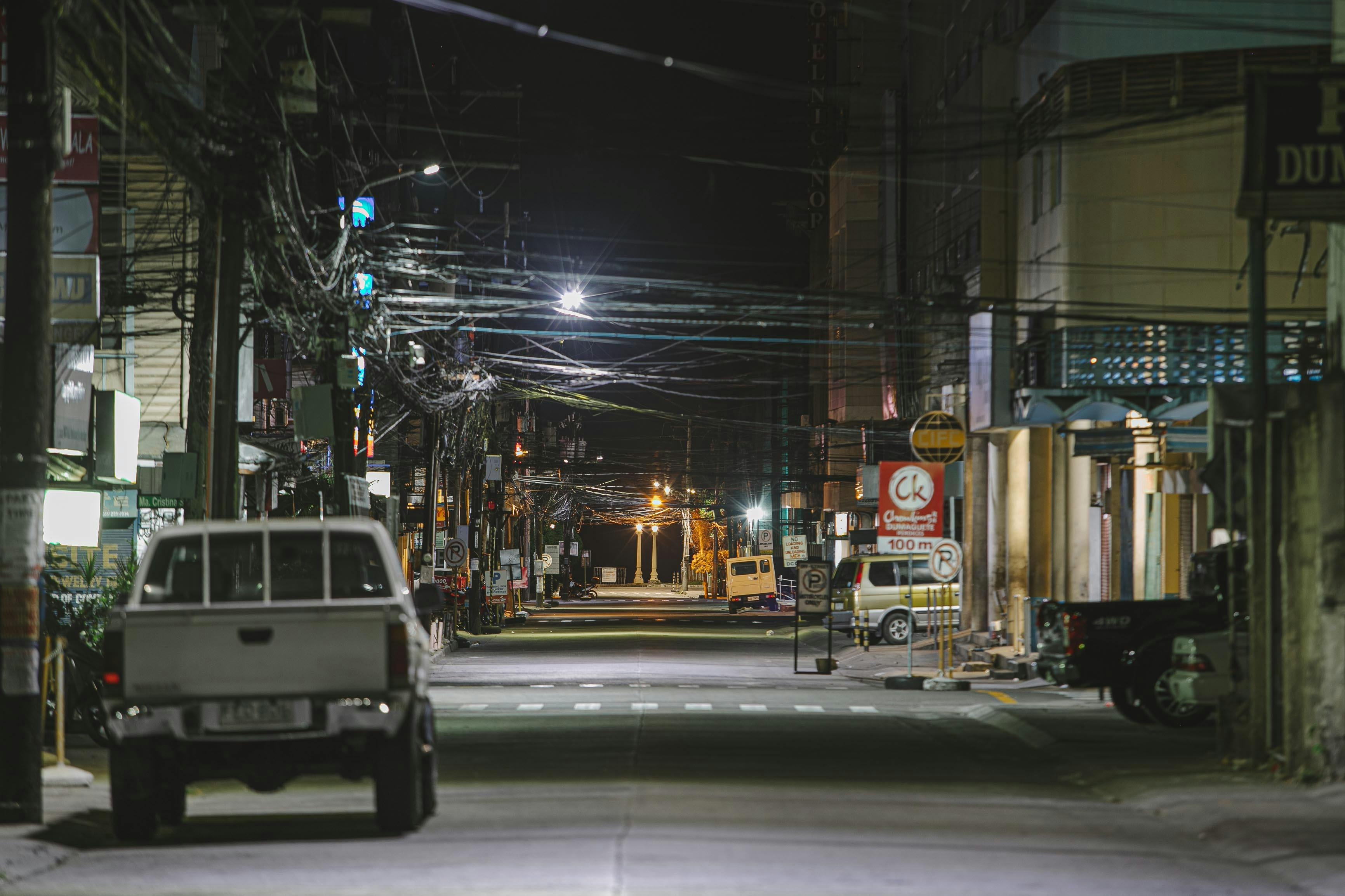 Bright street lamps illuminating modern building and road in evening ...