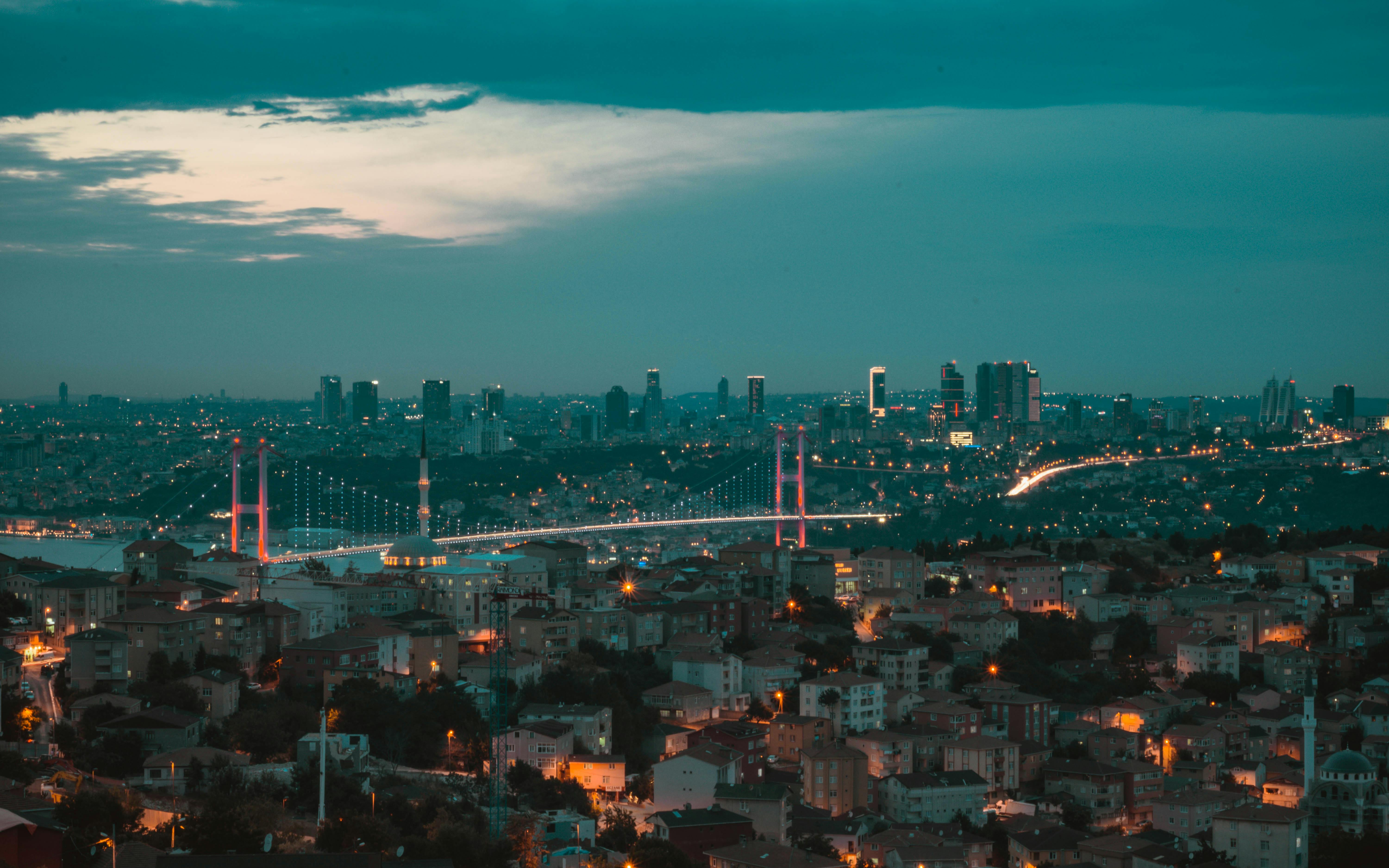Cityscape with illuminated bridge over river and old district in ...