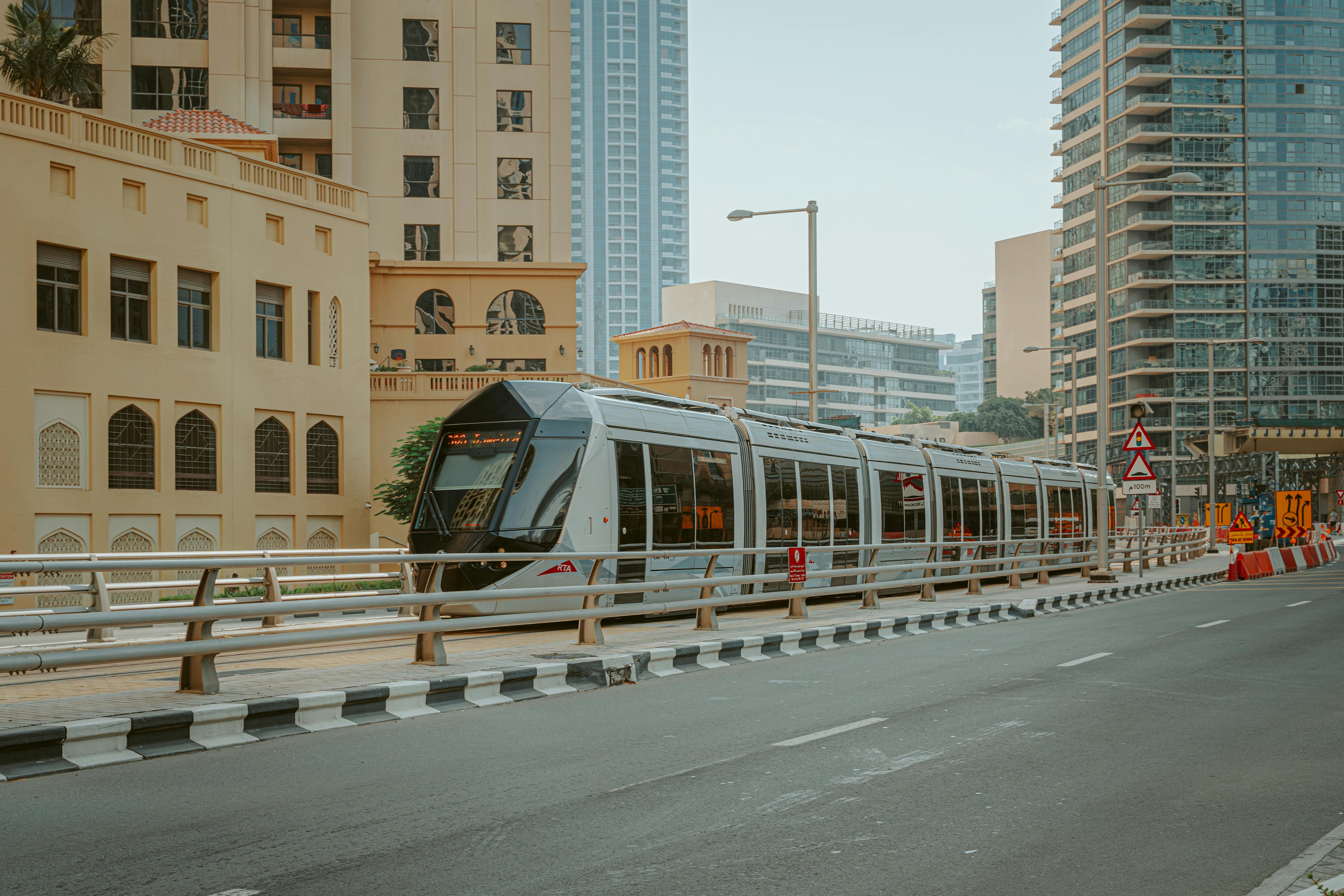 Modern public transport among high buildings · Free Stock Photo