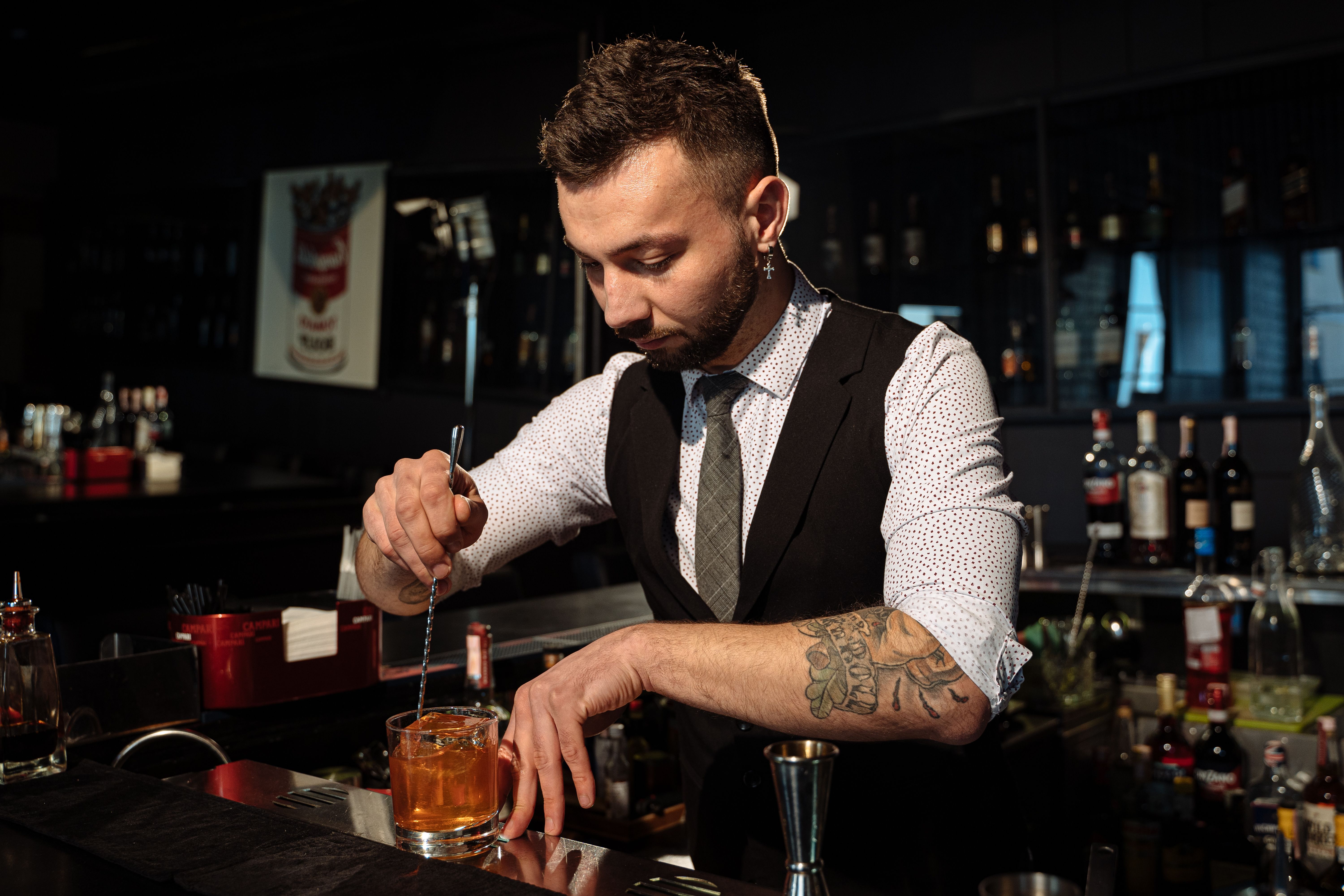 Man in White Dress Shirt Sitting on Chair in Front of Bar Counter ...