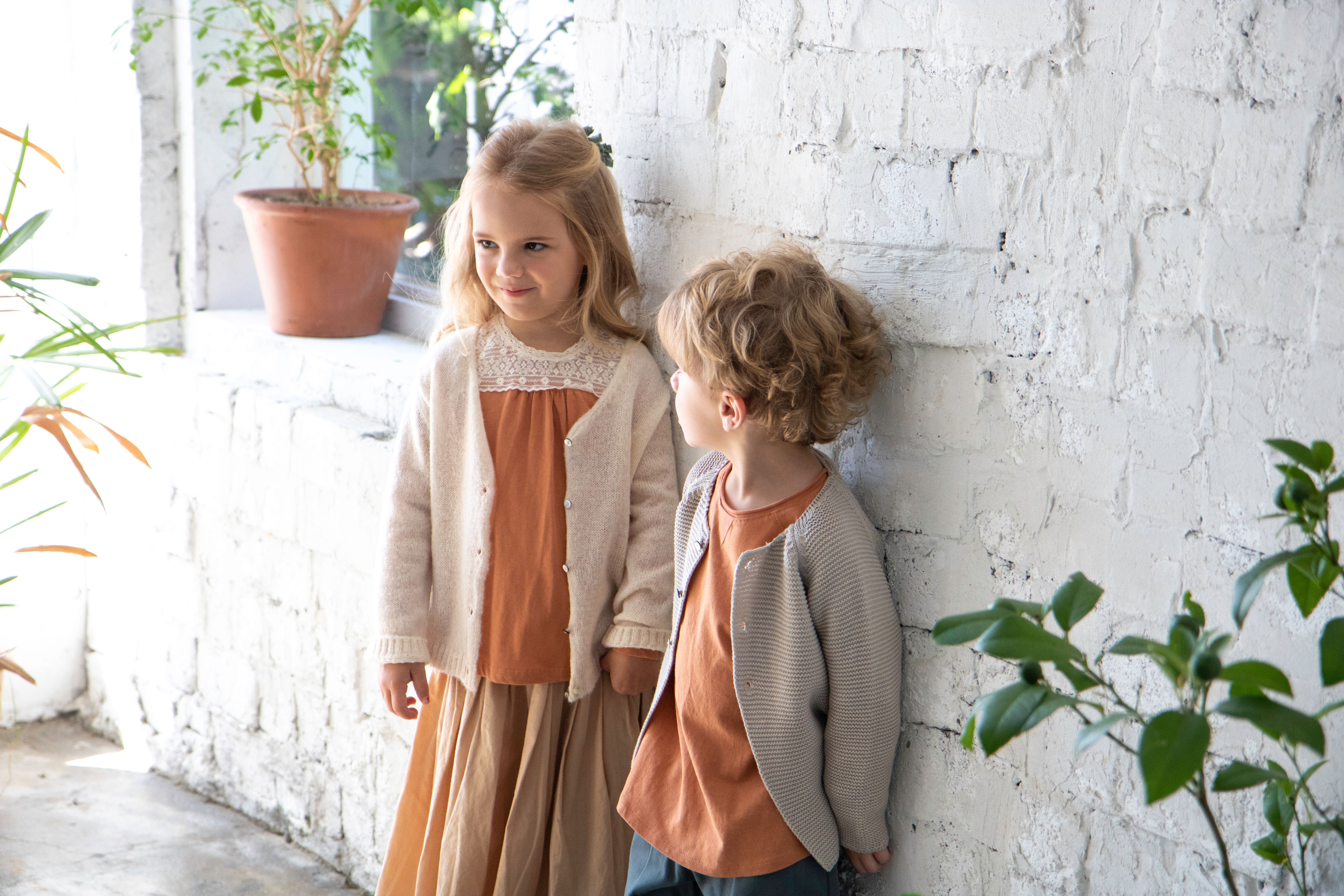 Two Children Standing Beside White Wall · Free Stock Photo