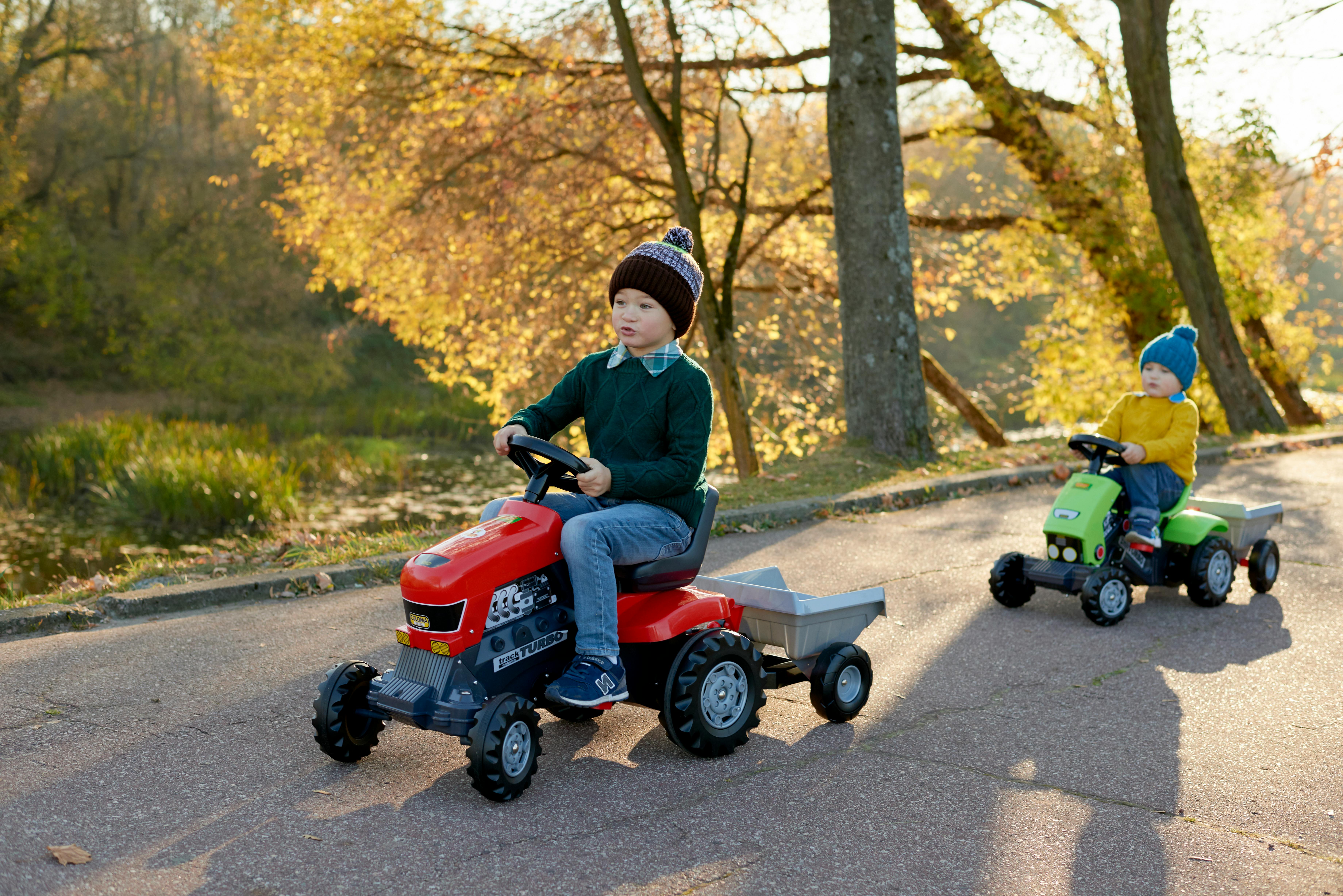 Young Boys Riding a Tractor Toys on the Street · Free Stock Photo