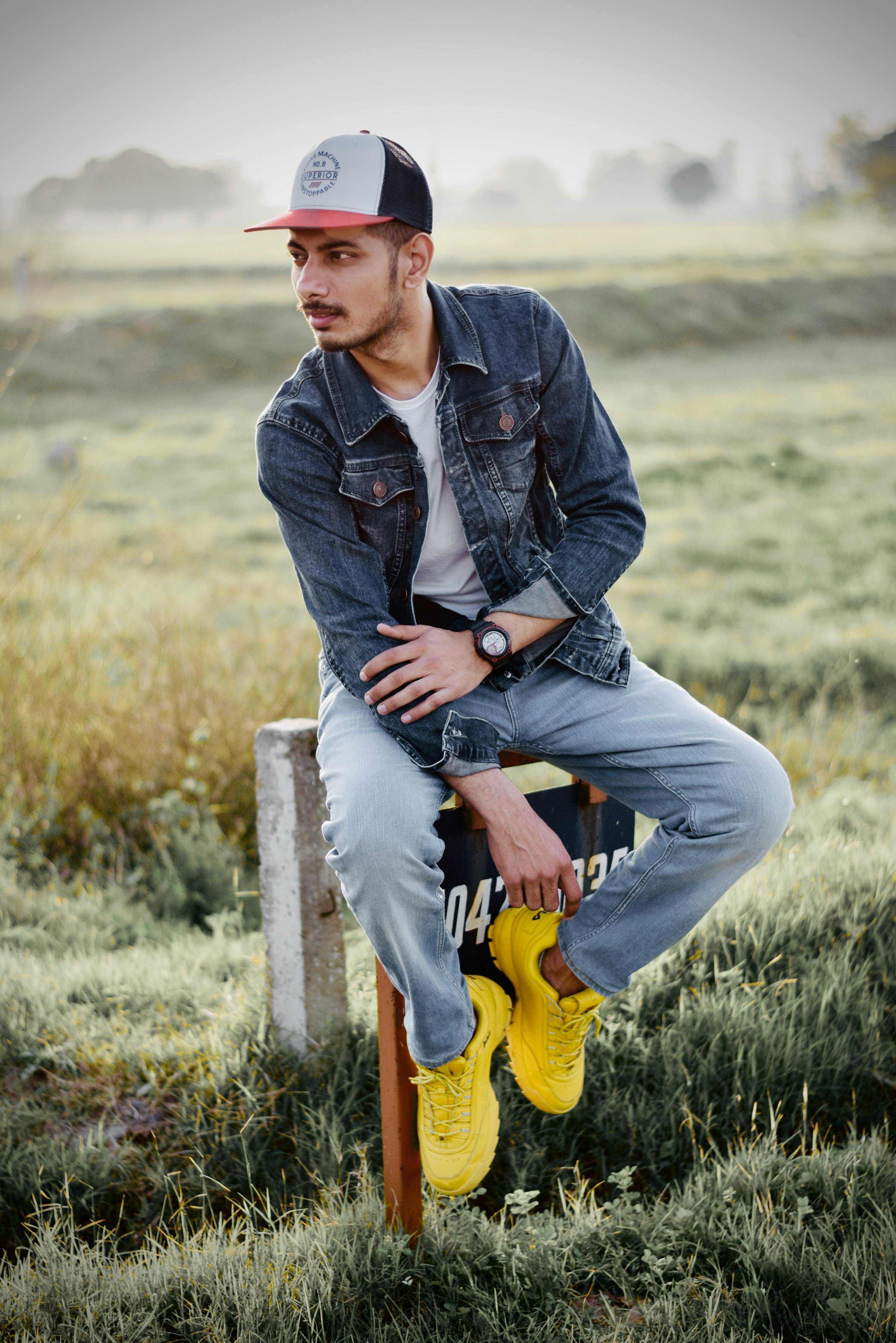 Young stylish ethnic man resting in field in countryside · Free Stock Photo