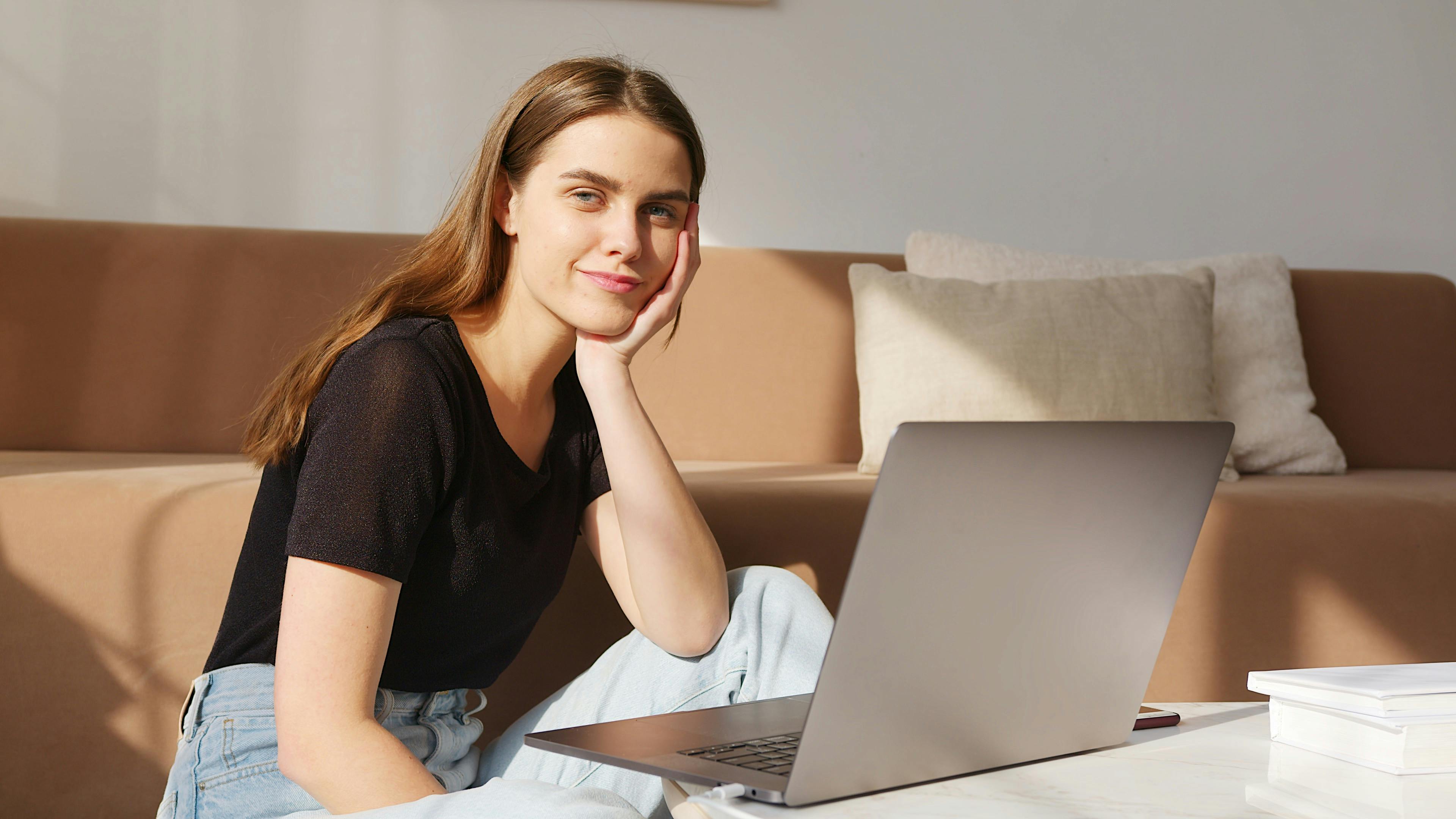 Content young woman using laptop and leaning head on hand · Free Stock ...
