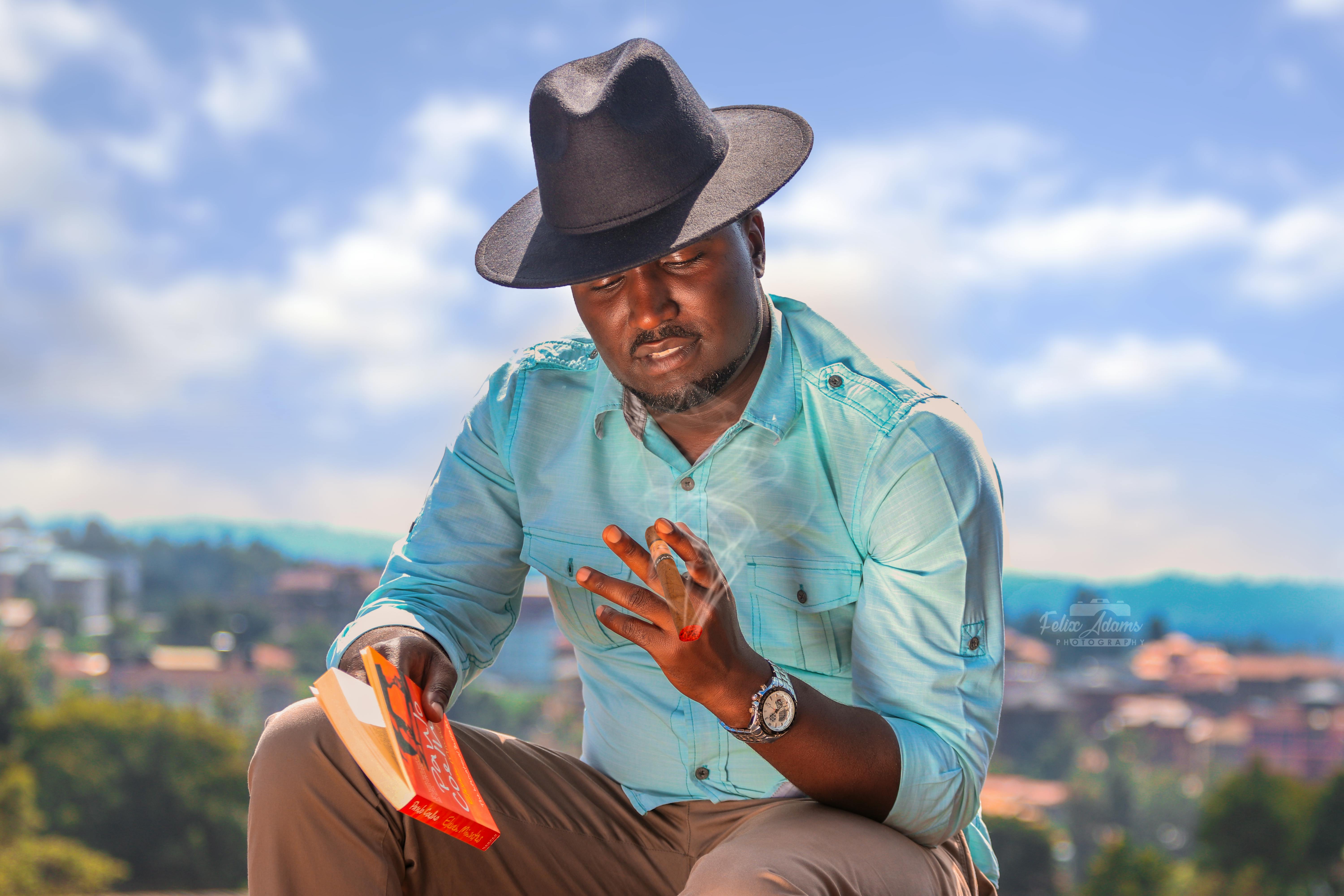 Black man in hat looking at smoldering cigar · Free Stock Photo