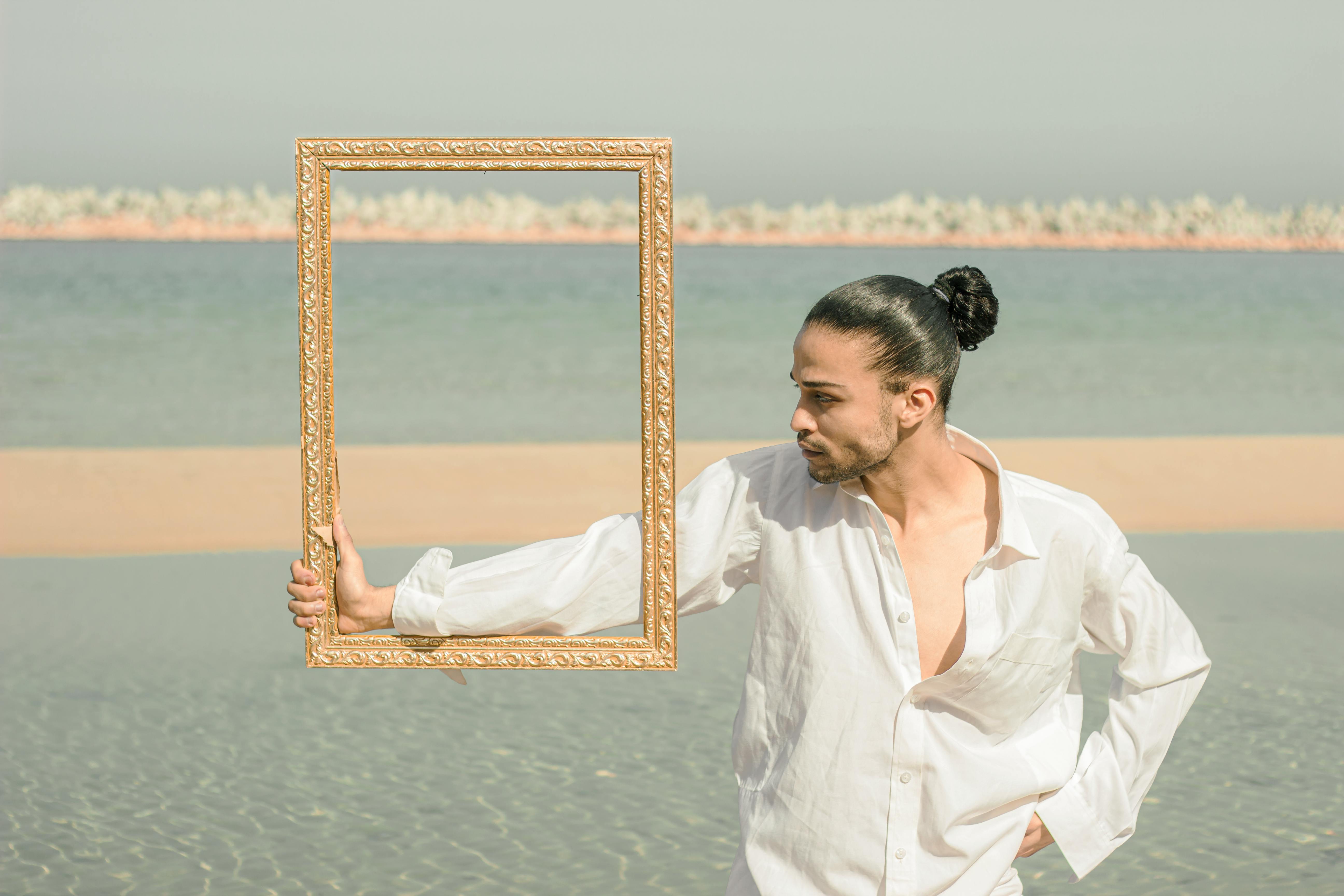 Portrait of a Man Holding a Frame · Free Stock Photo