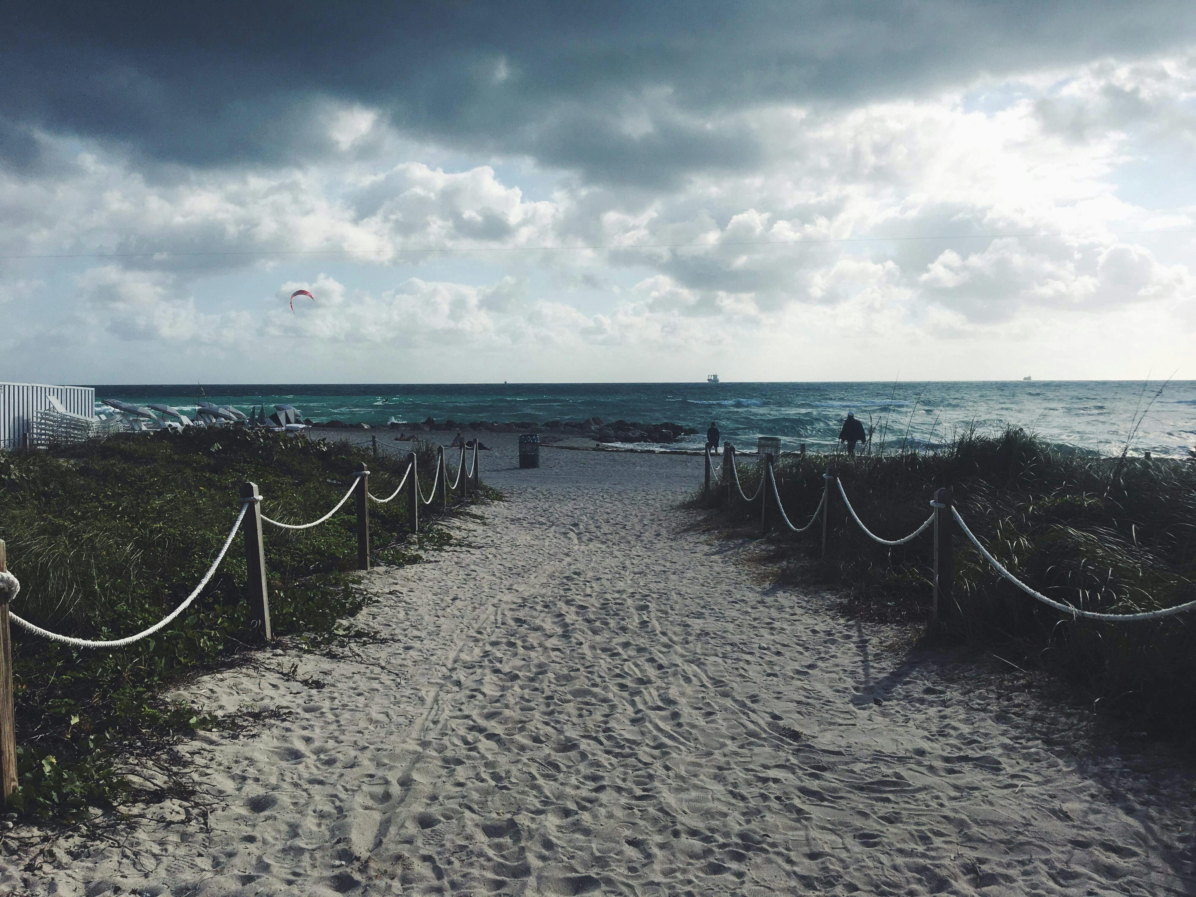 Sandy walkway to sea in overcast weather · Free Stock Photo