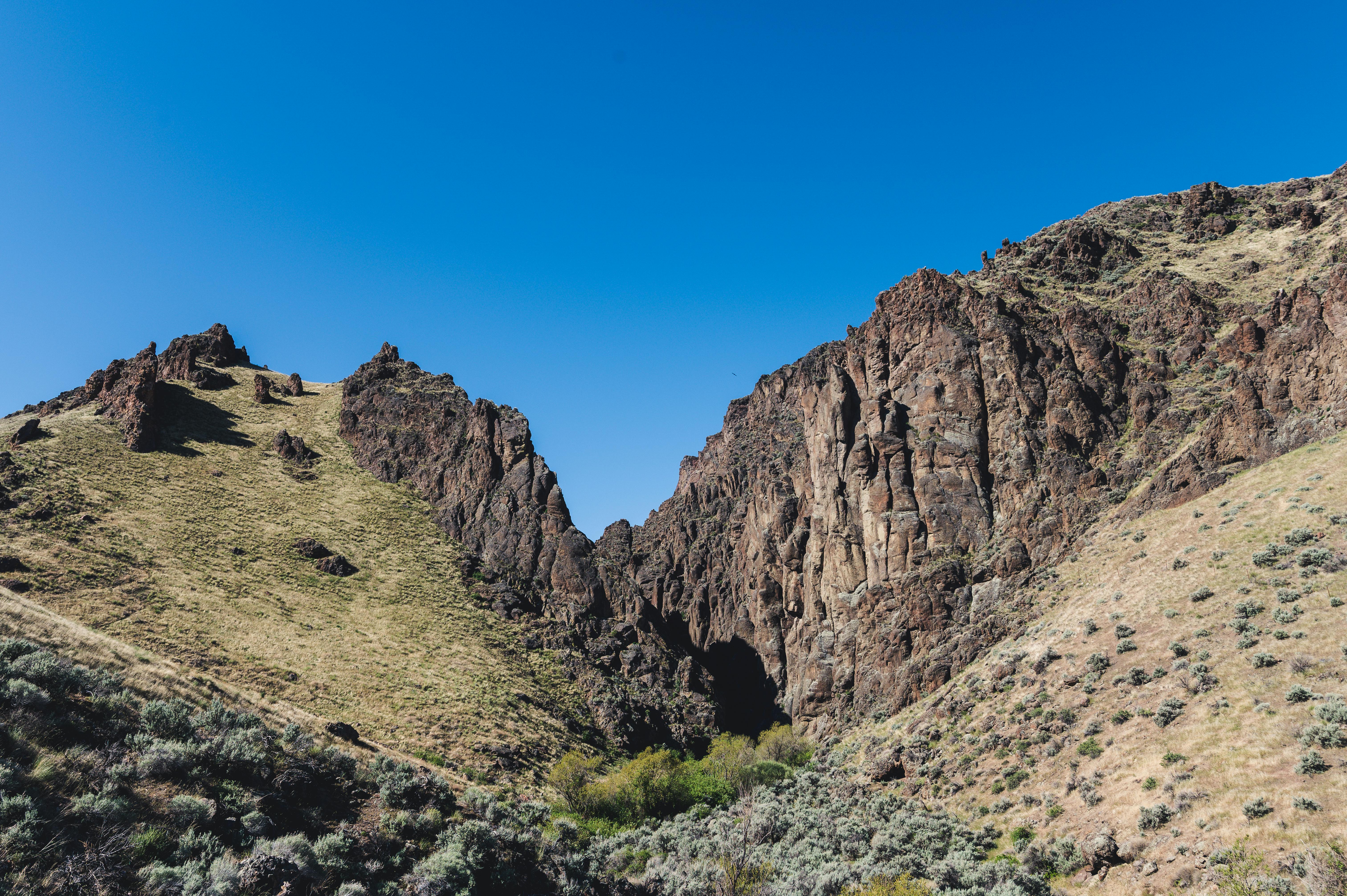 Rocky slopes with dry surface under blue sky · Free Stock Photo