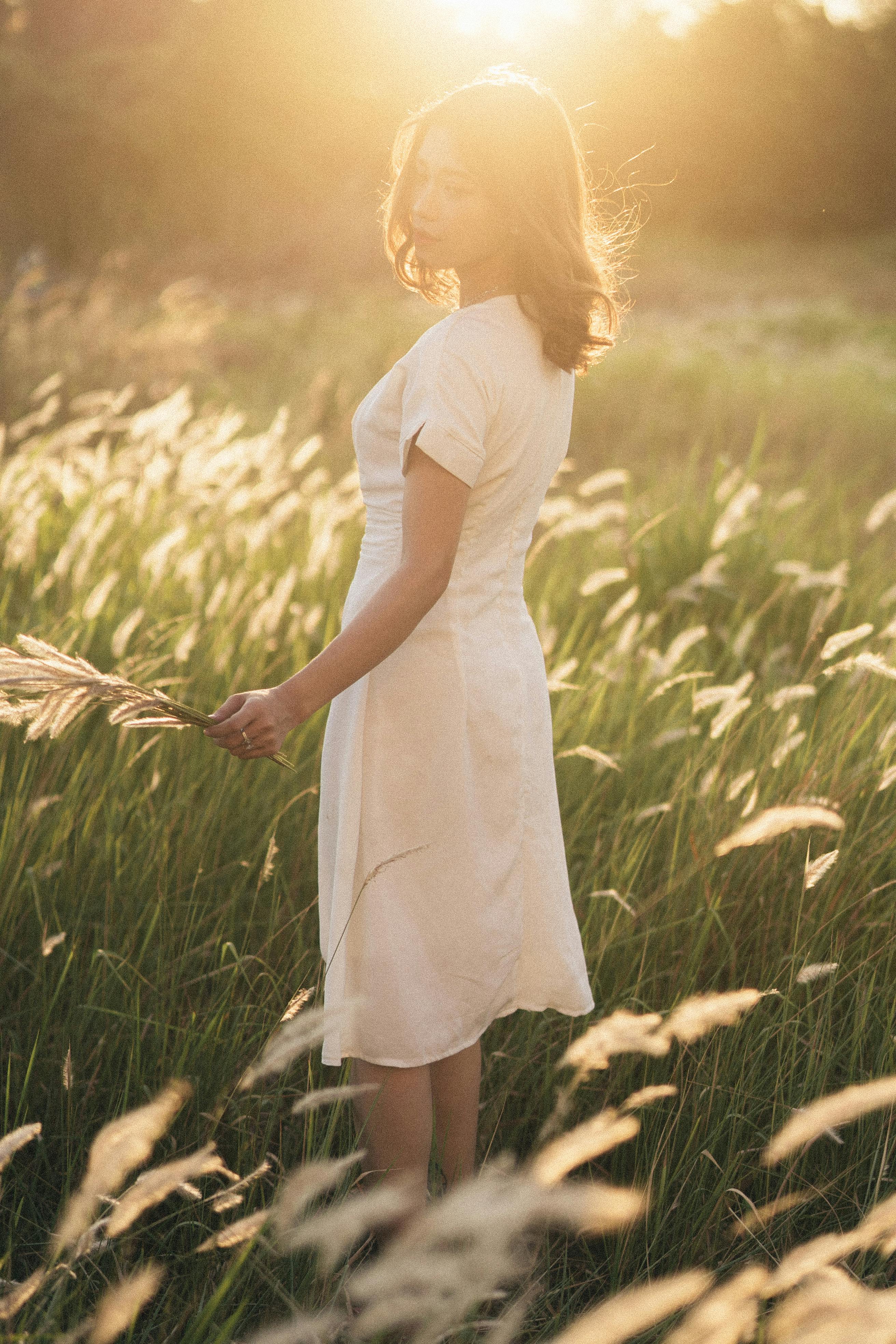 Wistful woman in dress with various balloons during festive event ...