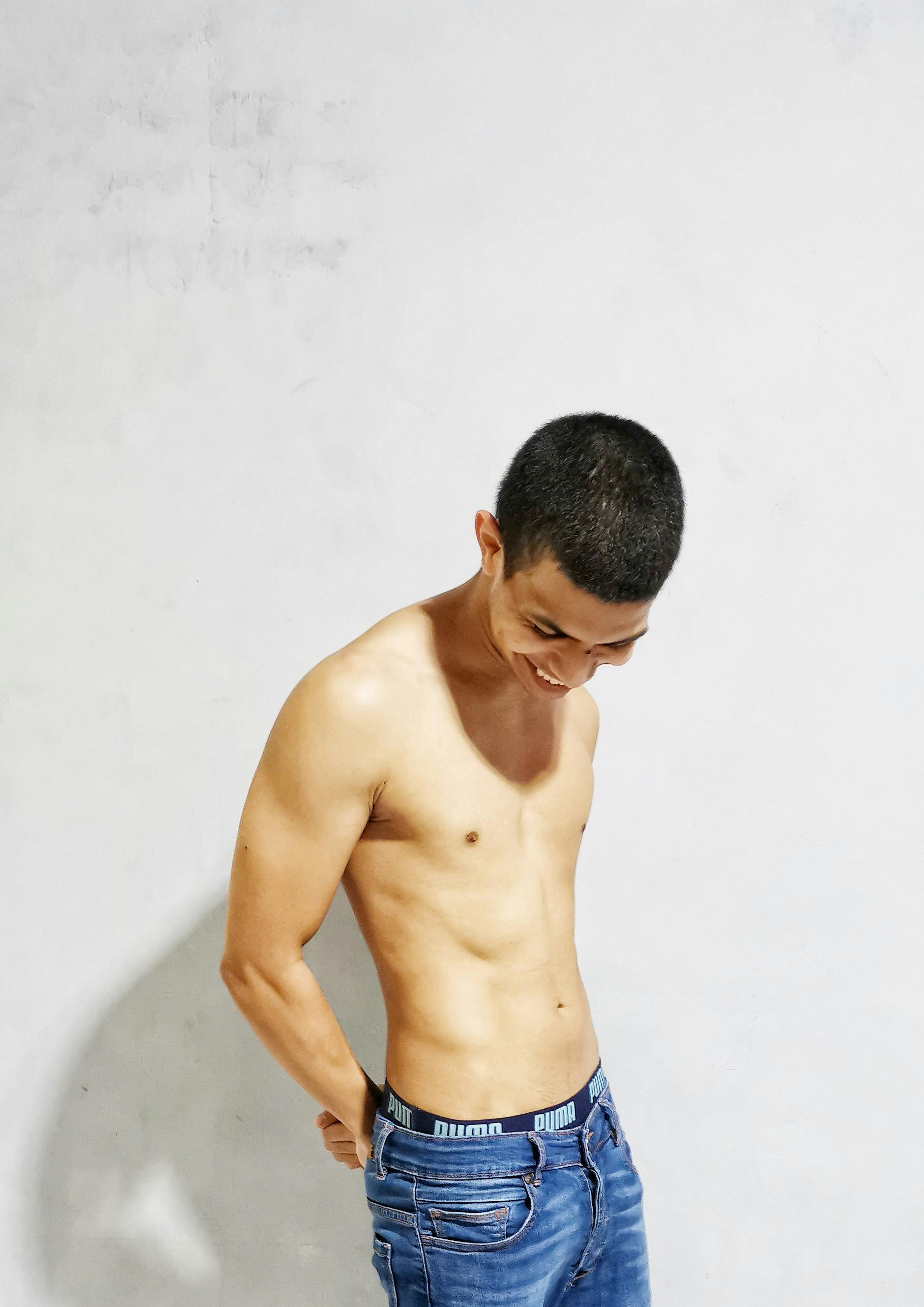 Shirtless Man Bowing Down with Hands Behind Back · Free Stock Photo