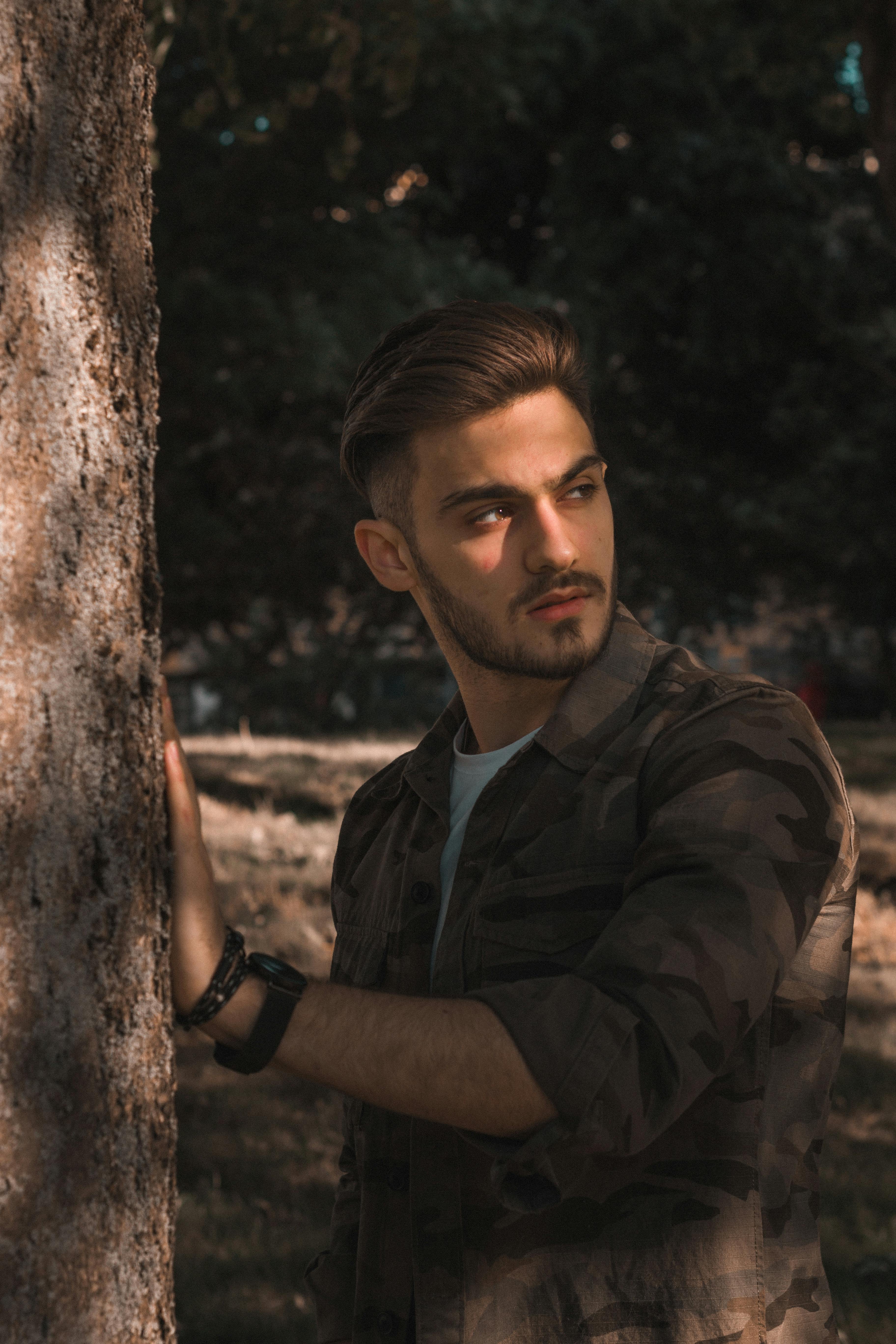 Thoughtful young male chilling in forest · Free Stock Photo