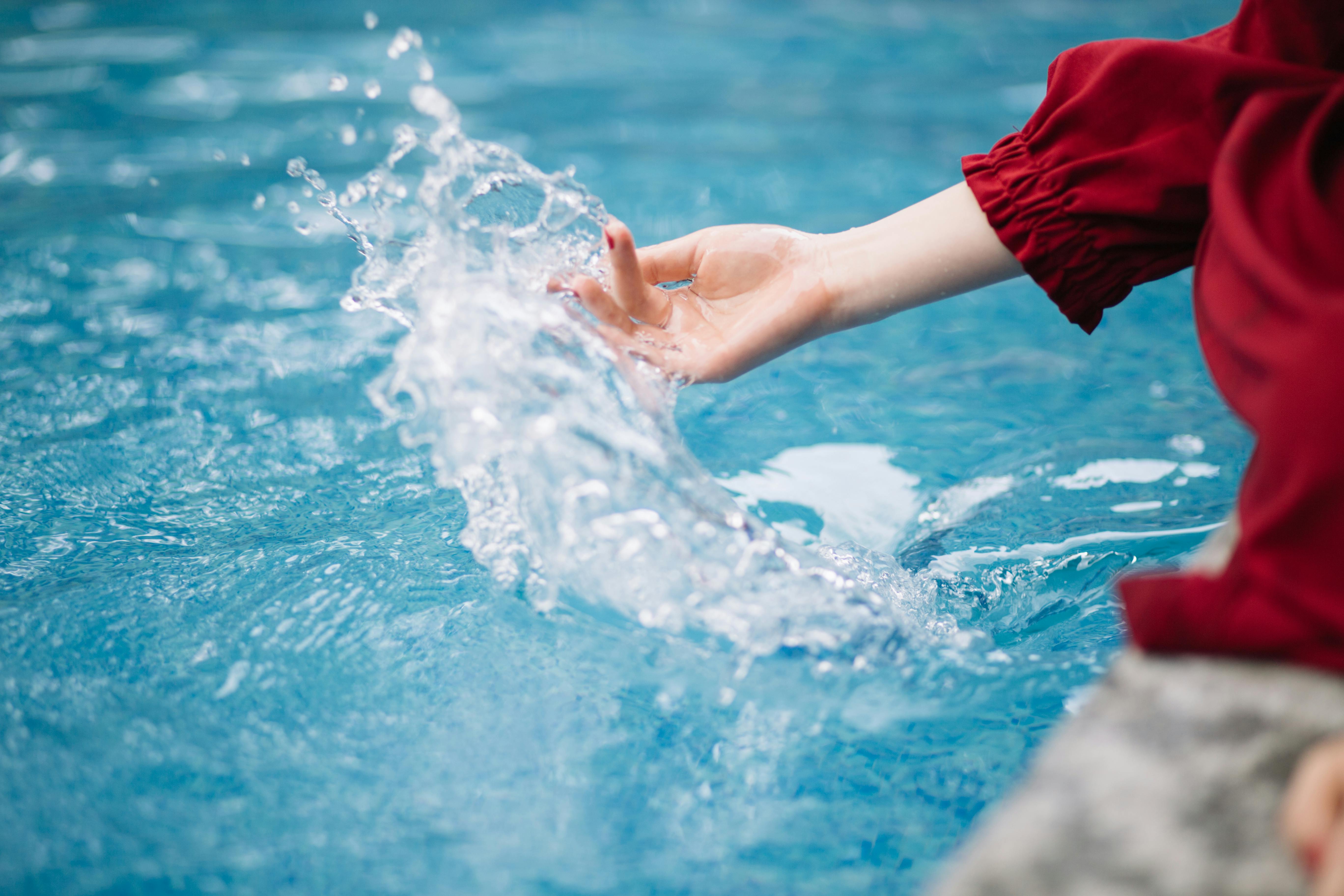 Woman Hand Splashing Water in Pool · Free Stock Photo